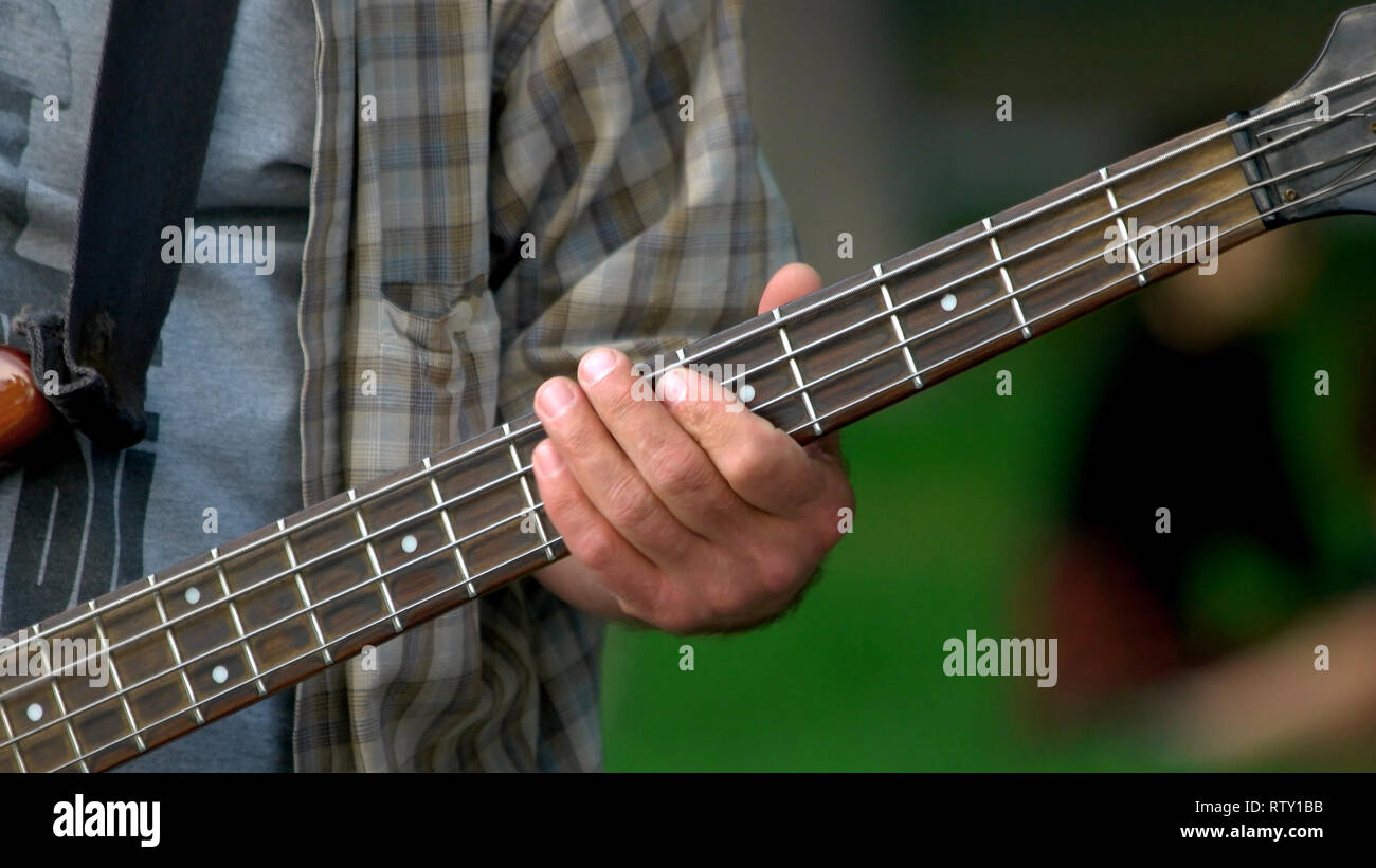 Male fingers holding guitar outdoors. Close up fingers of mature man on ...