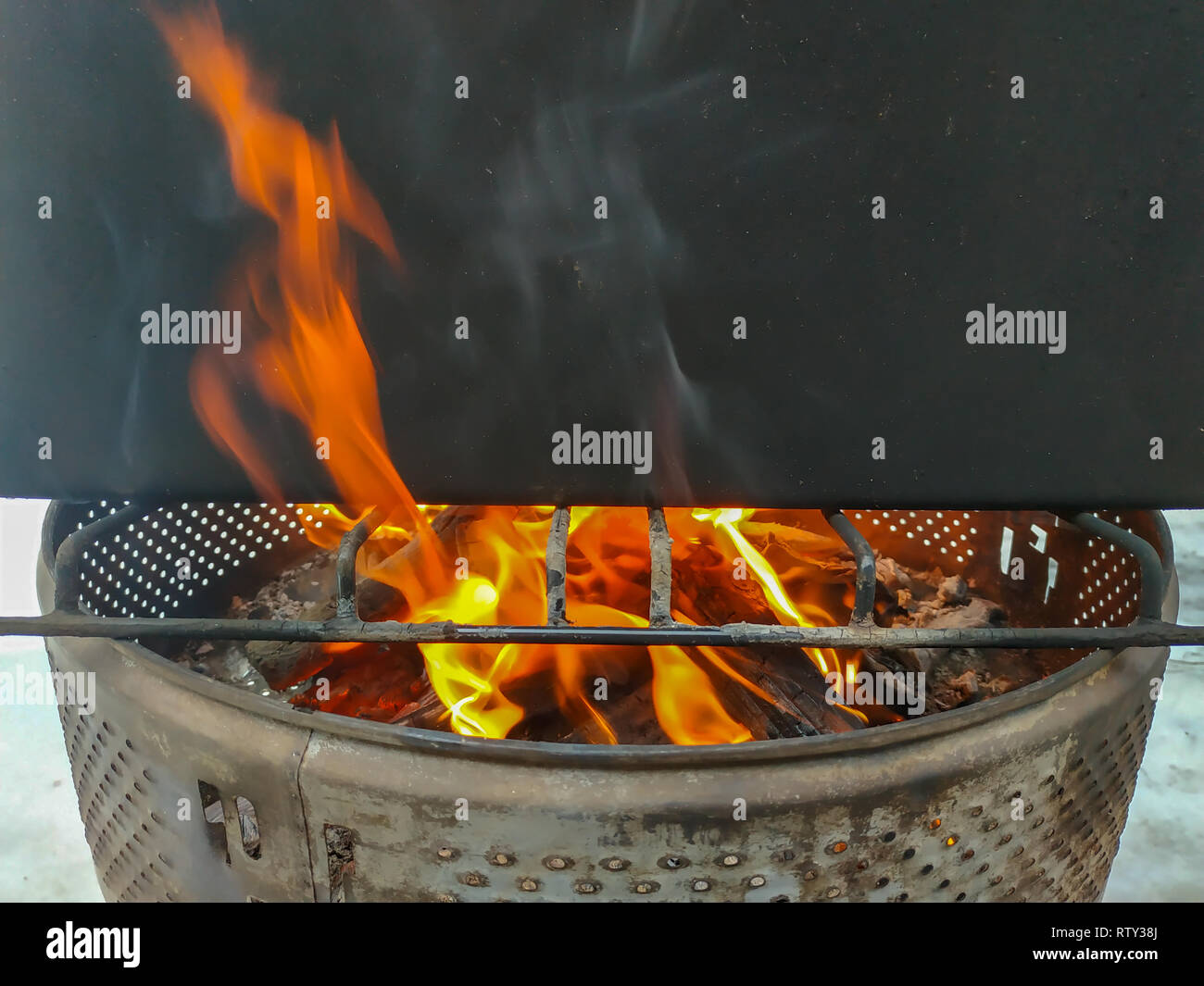 firewood burning in a fire warming up a barbecue and barbecue Stock ...