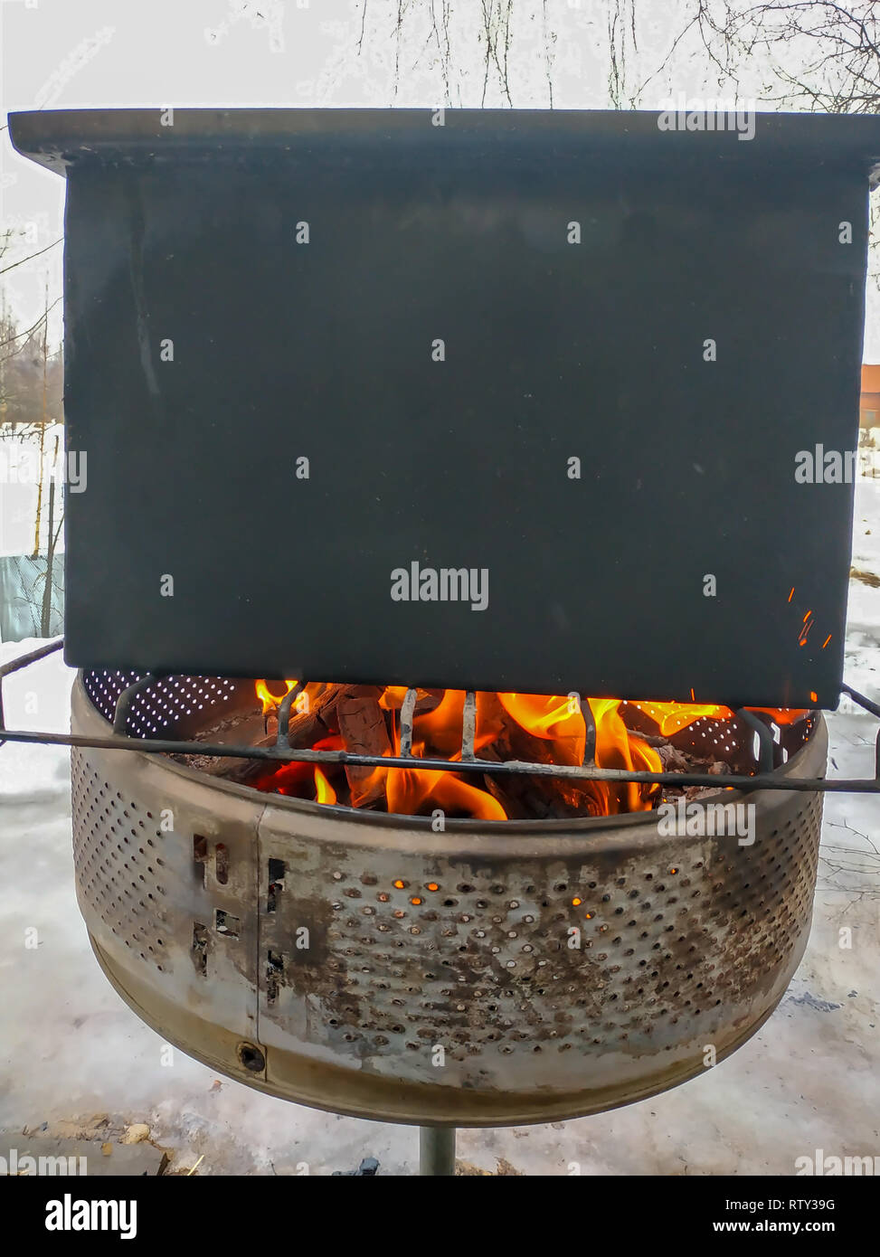 firewood burning in a fire warming up a barbecue and barbecue Stock ...