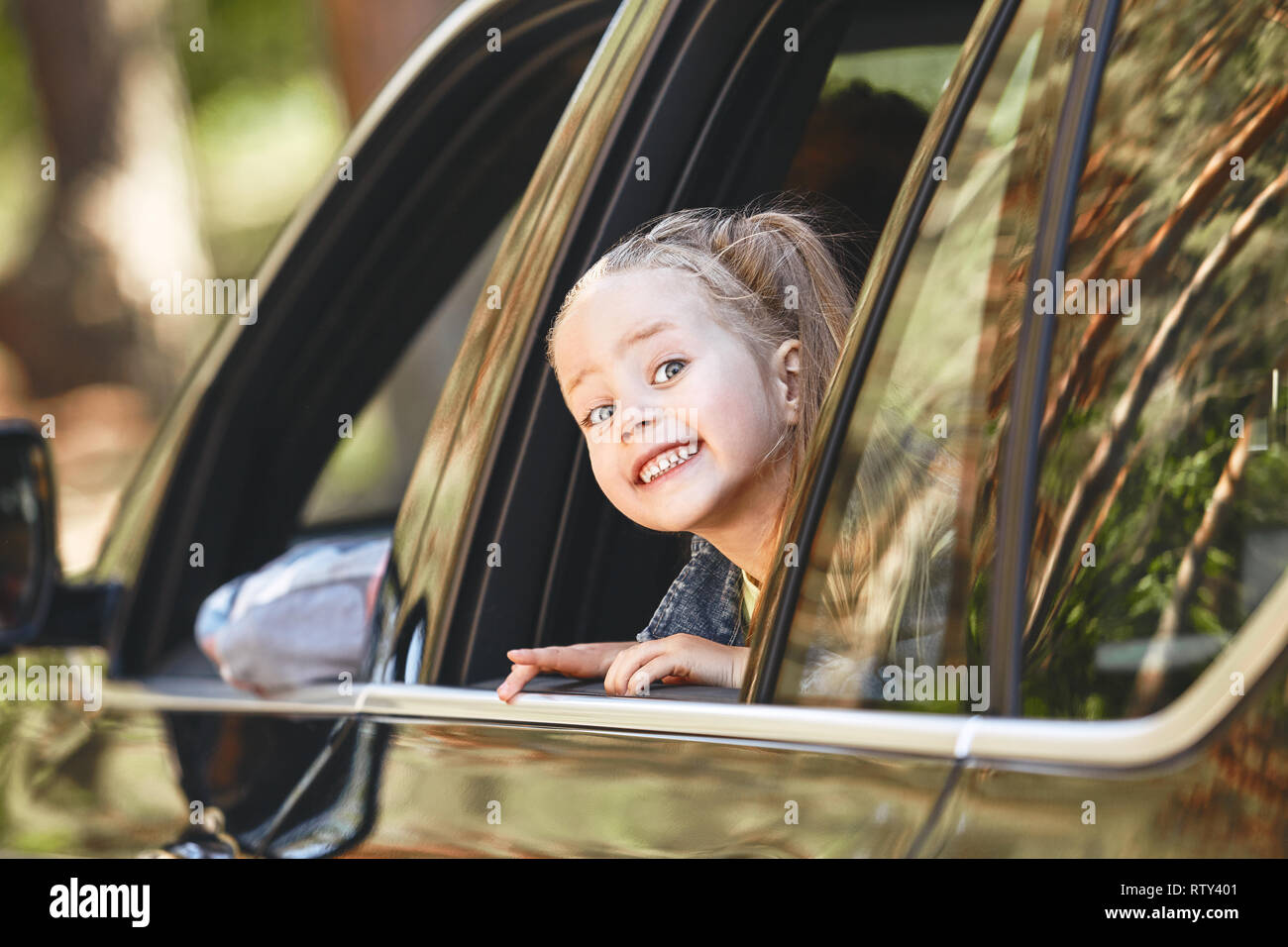 Five years old blond caucasian child girl looking out the window while ...