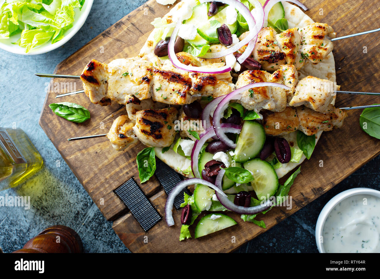 Chicken kebabs on a pita with vegetables and olives, greek inspired ...