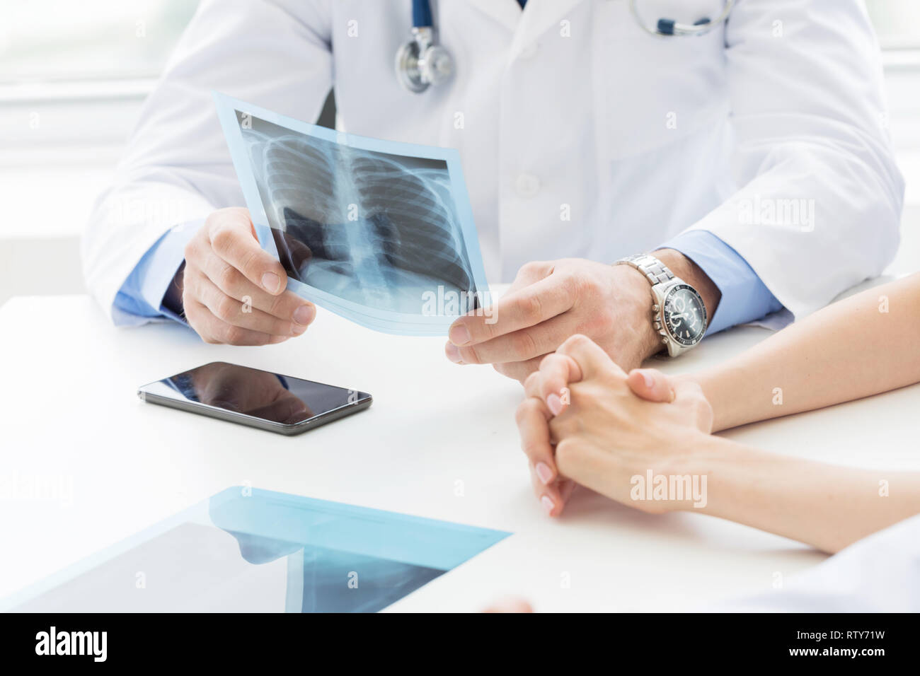 medical colleagues discuss x-ray sitting at the office table Stock ...
