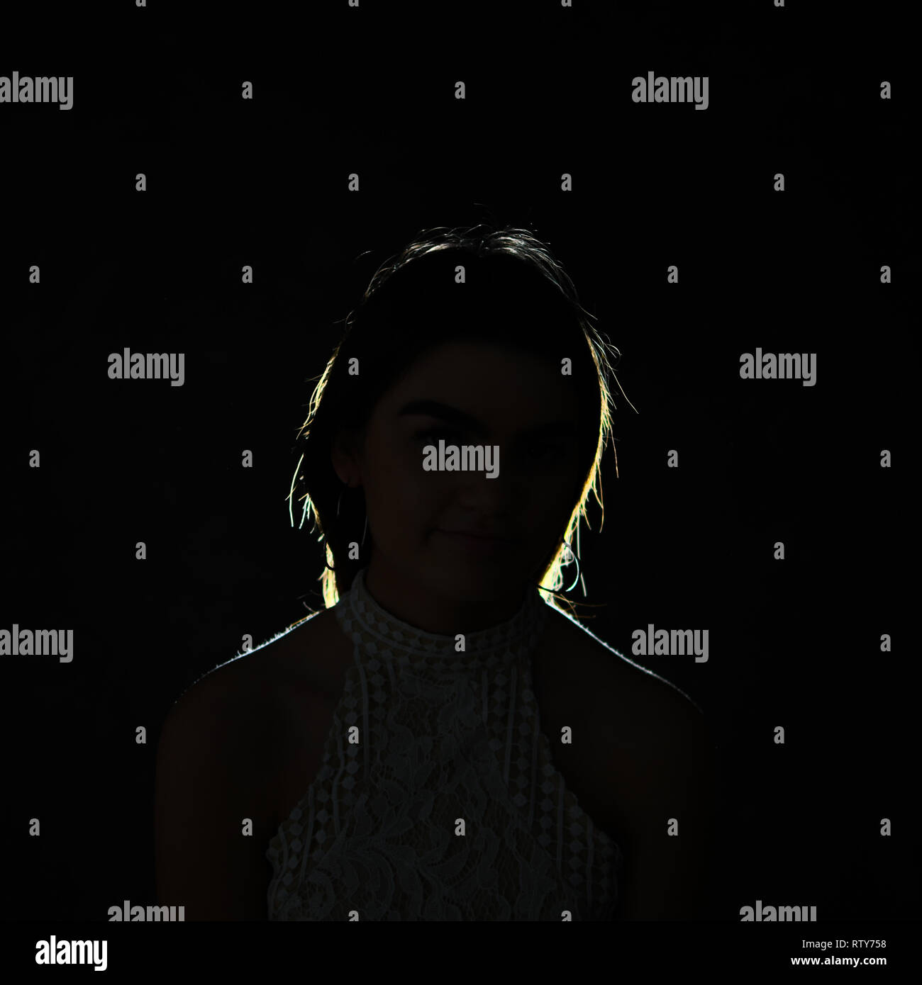 Dark, Backlit head and shoulders portrait of girl with light shining ...