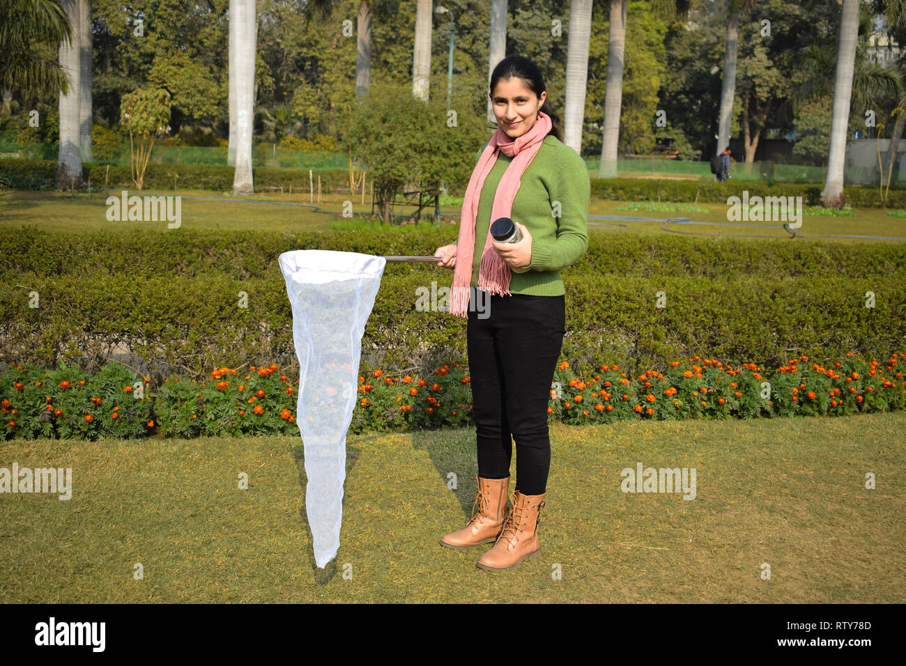Young woman entomologist collecting insects using an insect net or ...