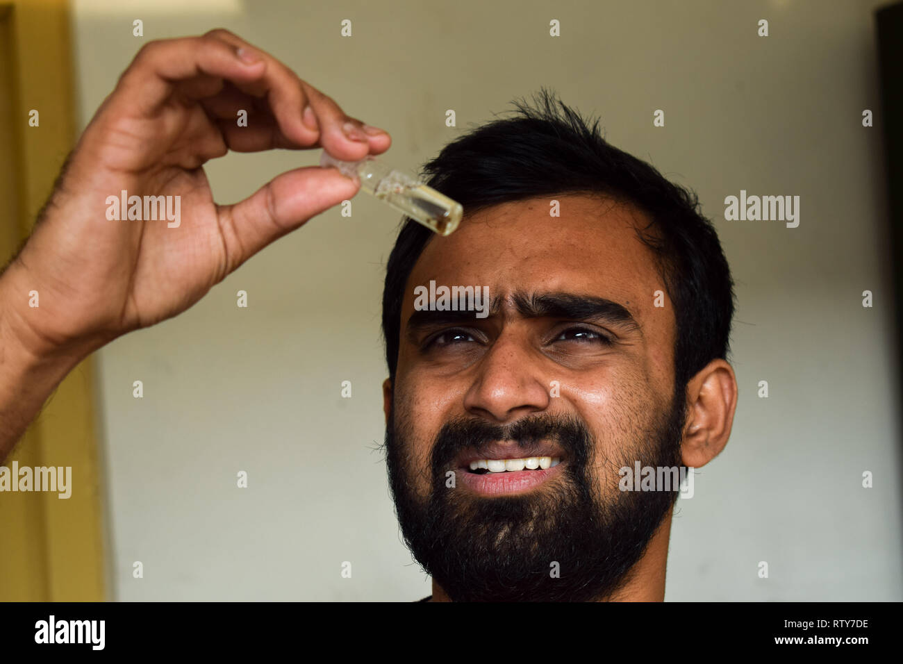 Young man entomologist observing insects in glass vile and trying to ...