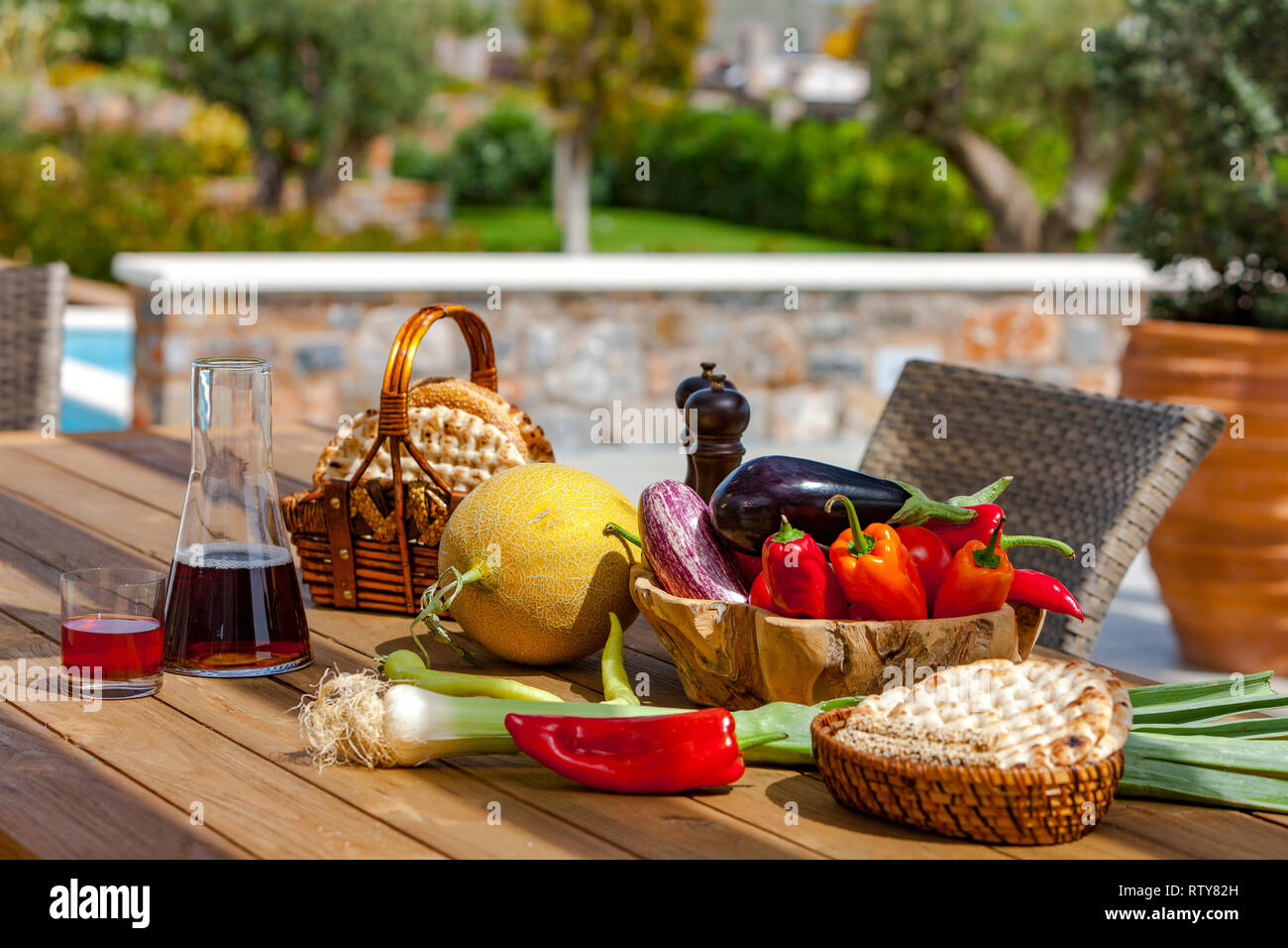 Fruits, vegetables, wine and bread on the table in the summer garden ...