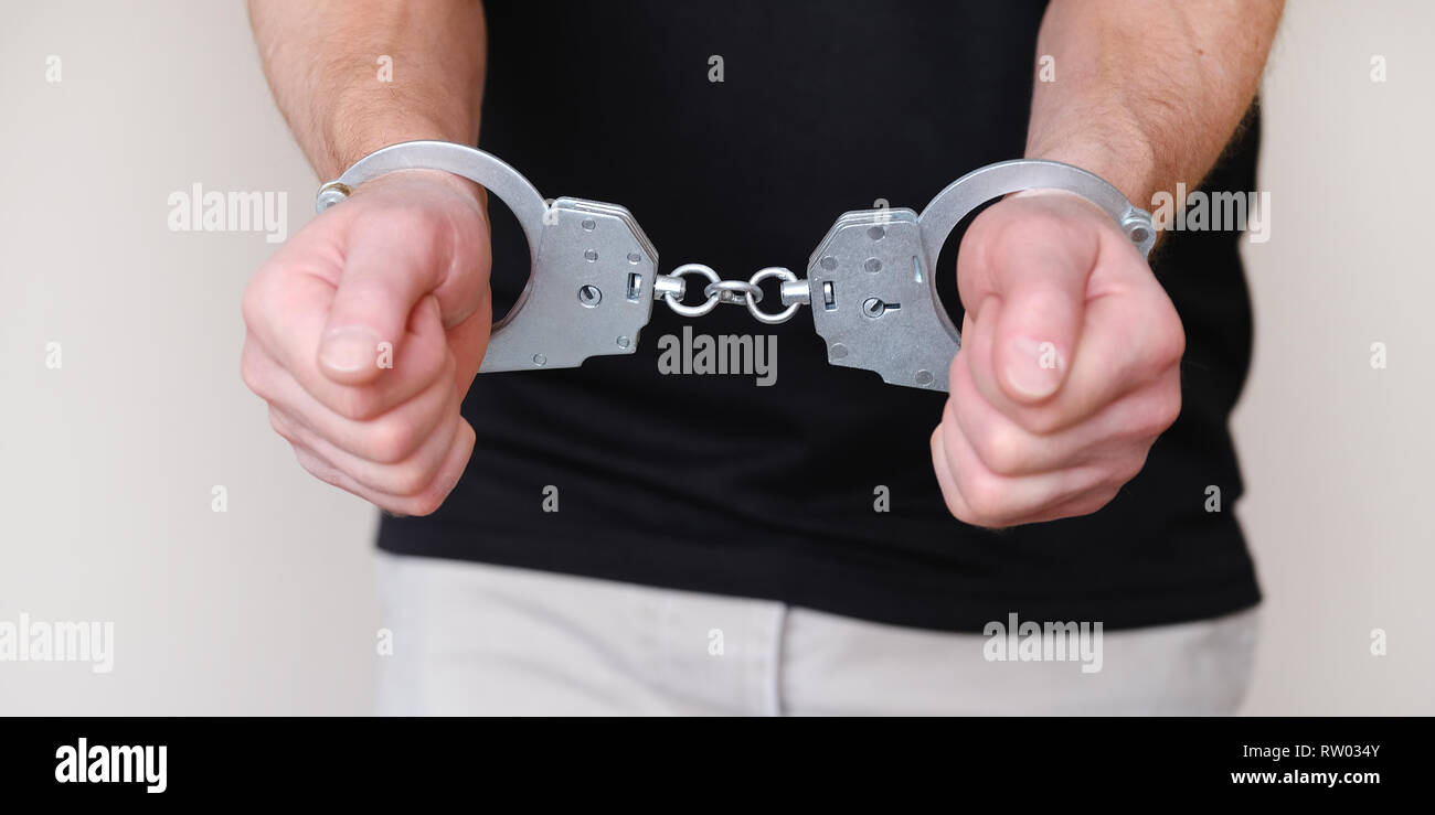 The man at the police station. Handcuffs on the wrists of the detained ...