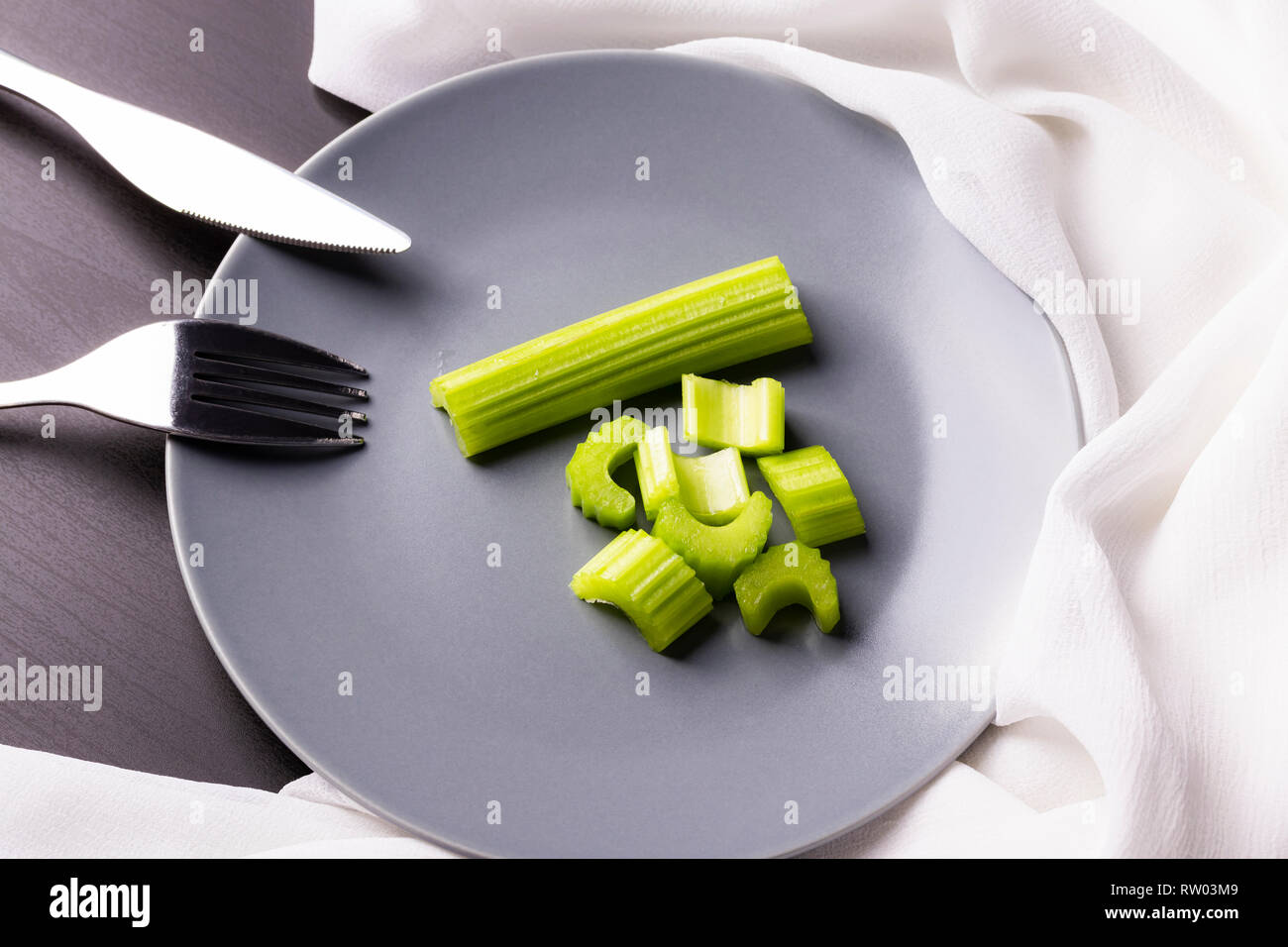 Sliced celery on a gray plate. White towel. Wooden table. Photo for the ...