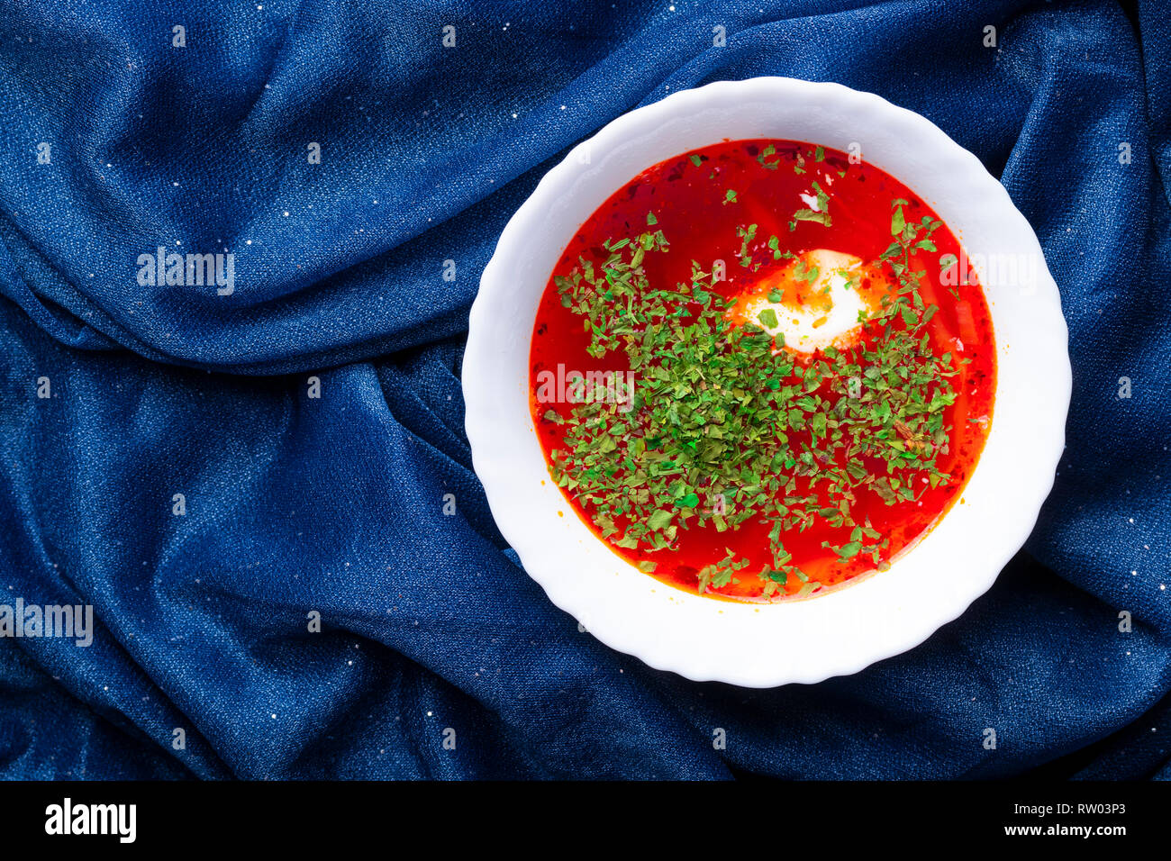 Russian and Ukrainian borsch with sour cream and parsley. Blue towel ...