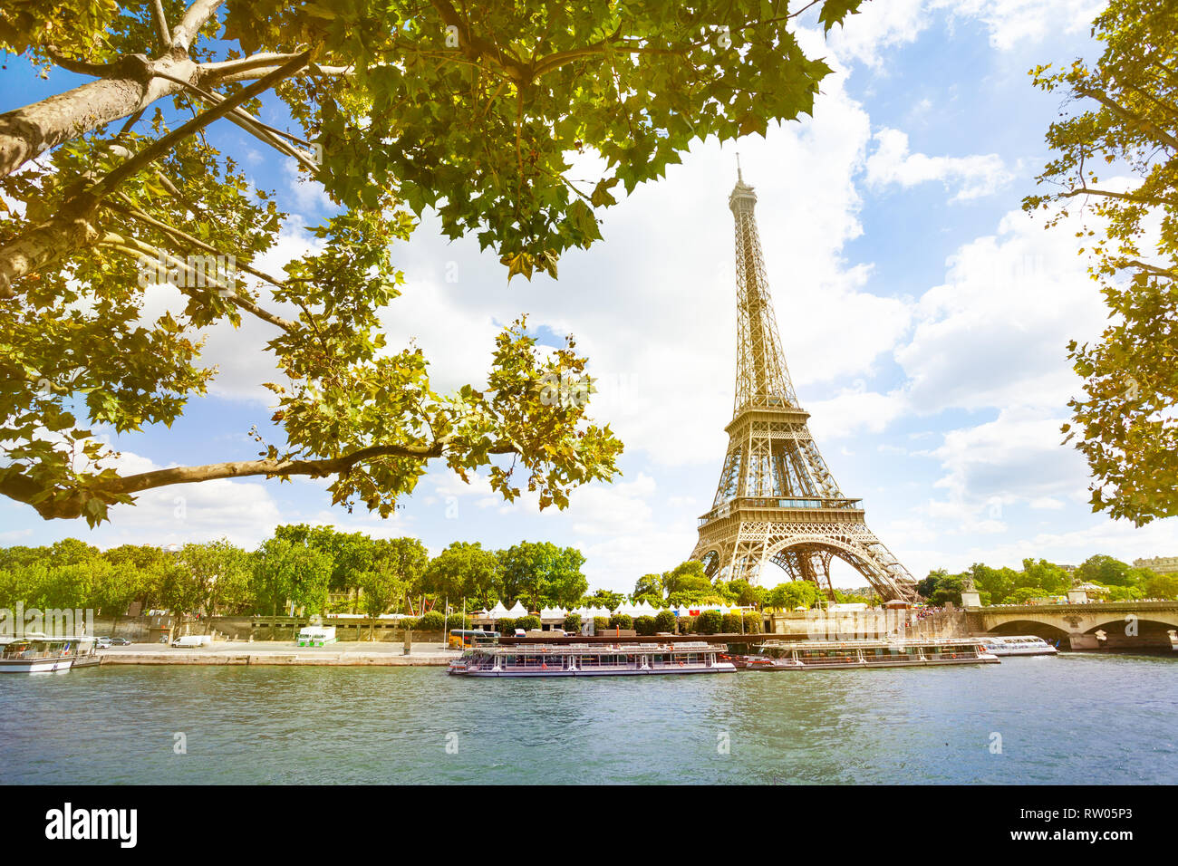View over Seine river on Eifel tower through sunny sky and trees ...