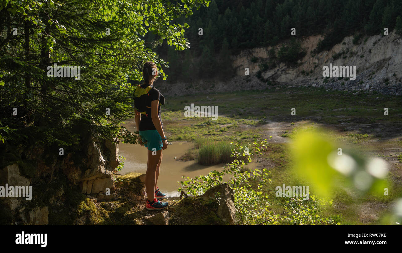 The girl stands at the edge of the cliff. Girl athlete is going to run ...