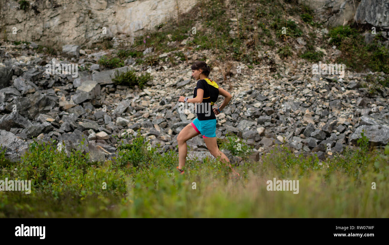 Girl athlete runs a long trail running on a beautiful area along the ...