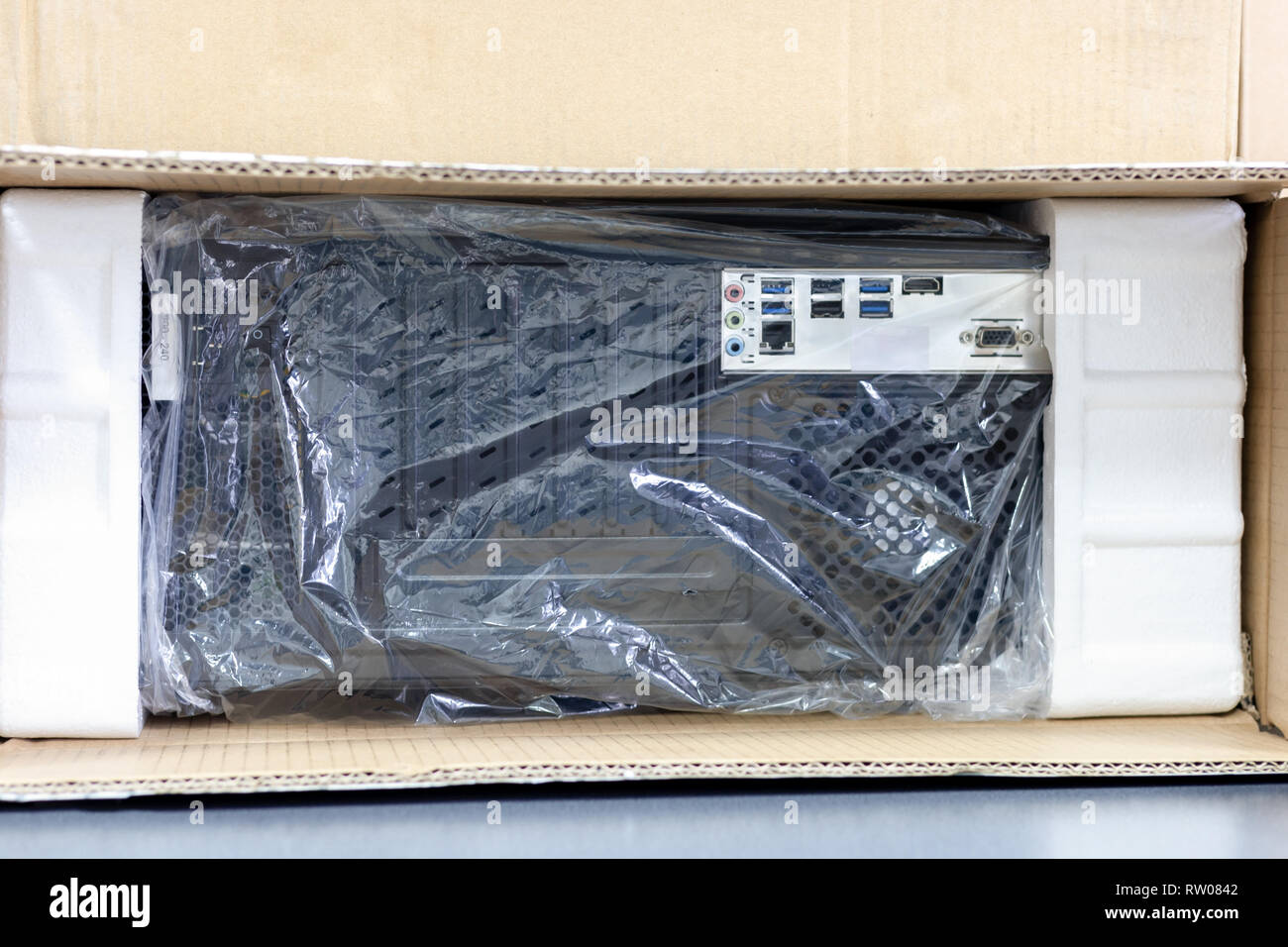 unpacking black personal computer, back view, cellophane packaging ...