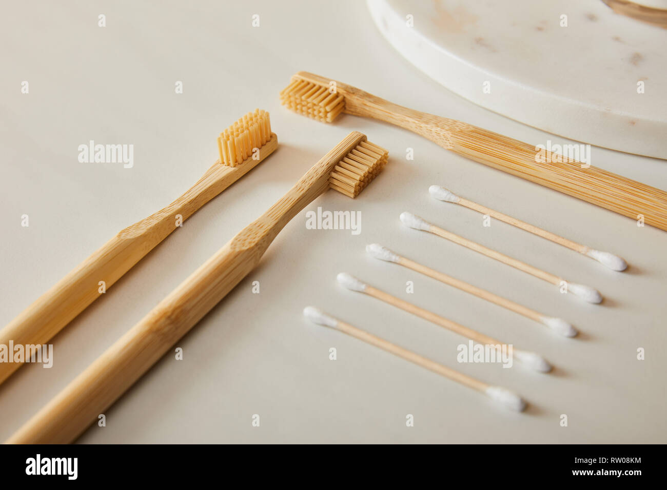 marble round board, bamboo toothbrushes and ear sticks on white ...