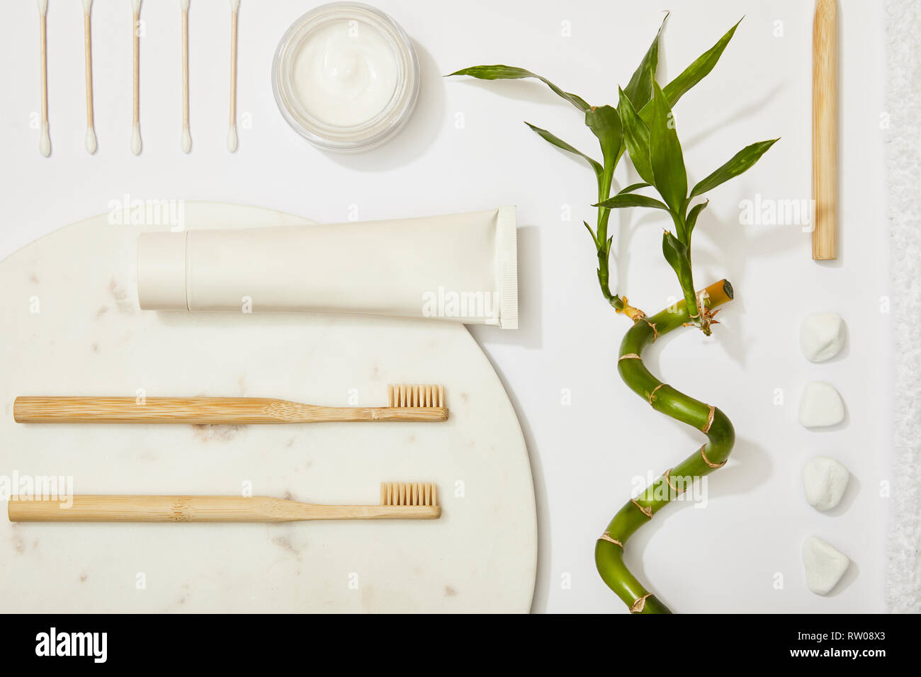 top view of marble round board with toothbrushes and toothpaste in tube ...