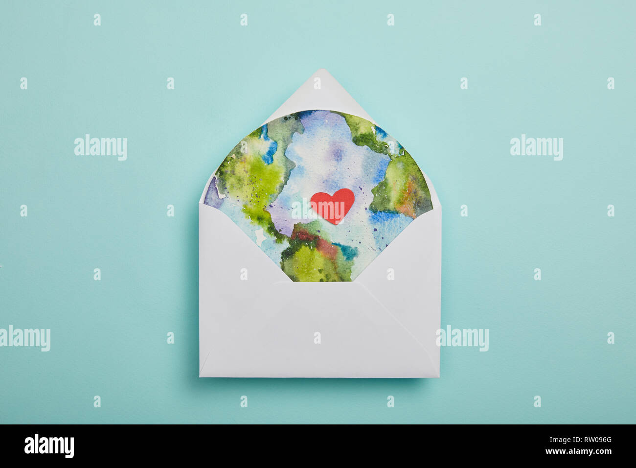 top view of envelope with planet picture on turquoise background, earth ...