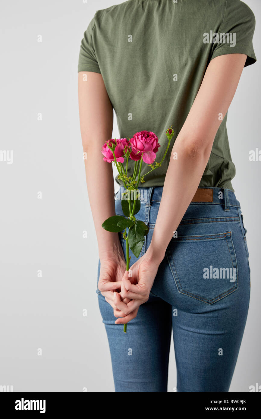back view of girl holding pink roses isolated on grey Stock Photo - Alamy