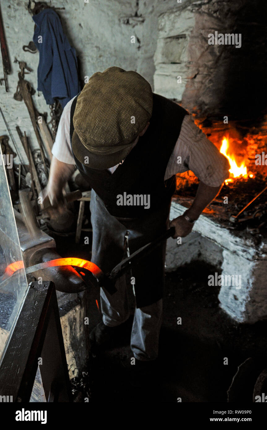 A blacksmith working in his smithy at the National Folk Museum in a ...