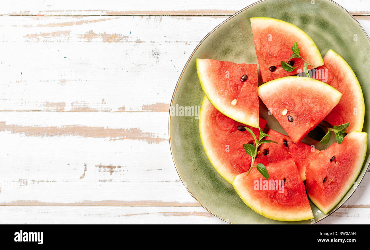 Sliced watermelon in big green plate and white background. Flat lay ...