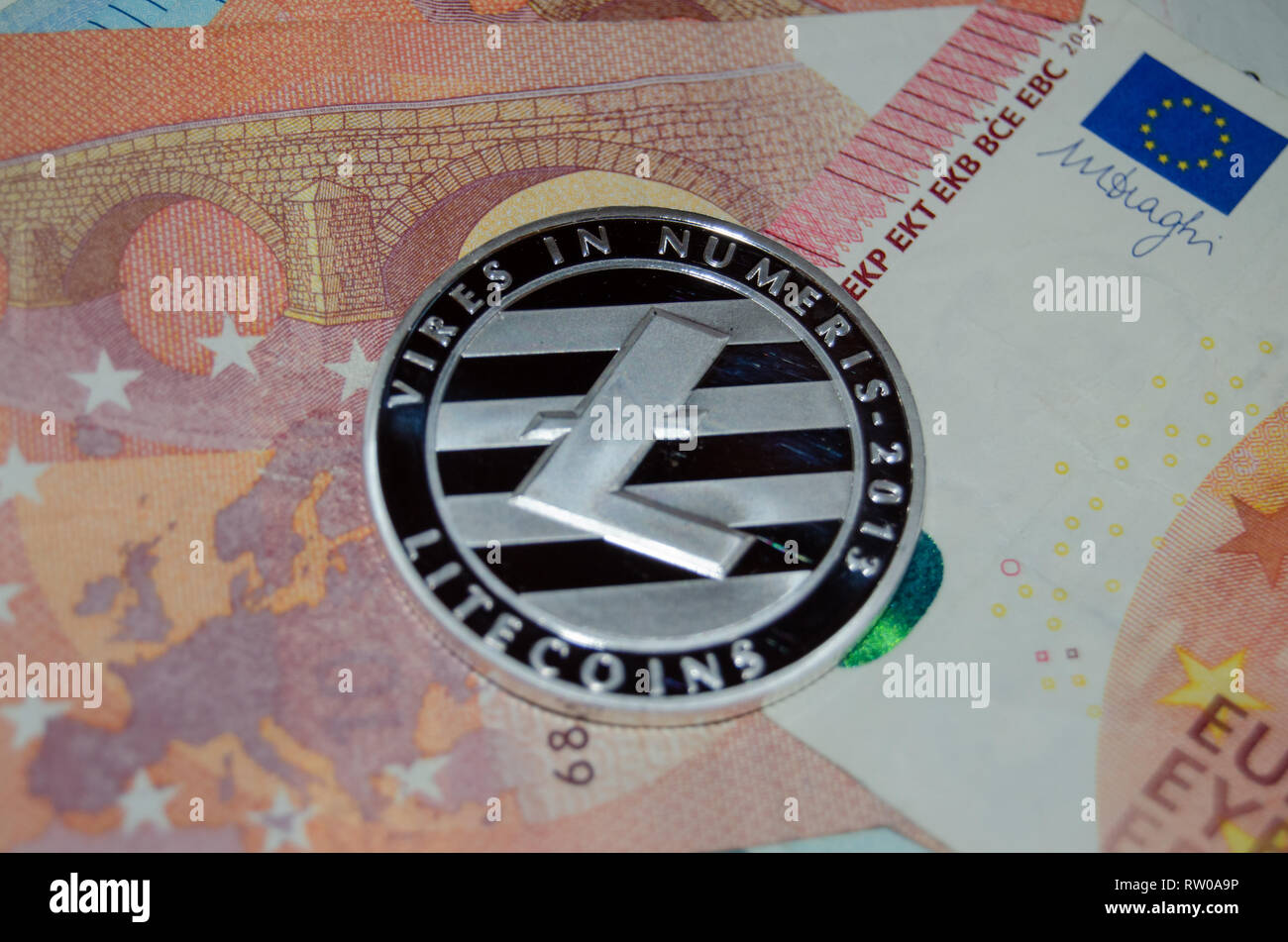 litecoin close up on top of euro paper monete virtual currency concept ...