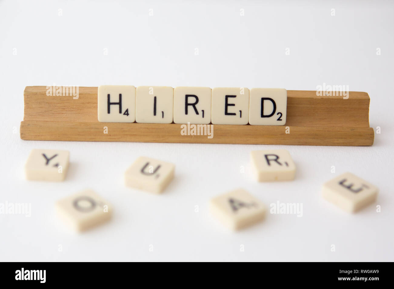 Tiles spell out the word 'hired' Stock Photo - Alamy