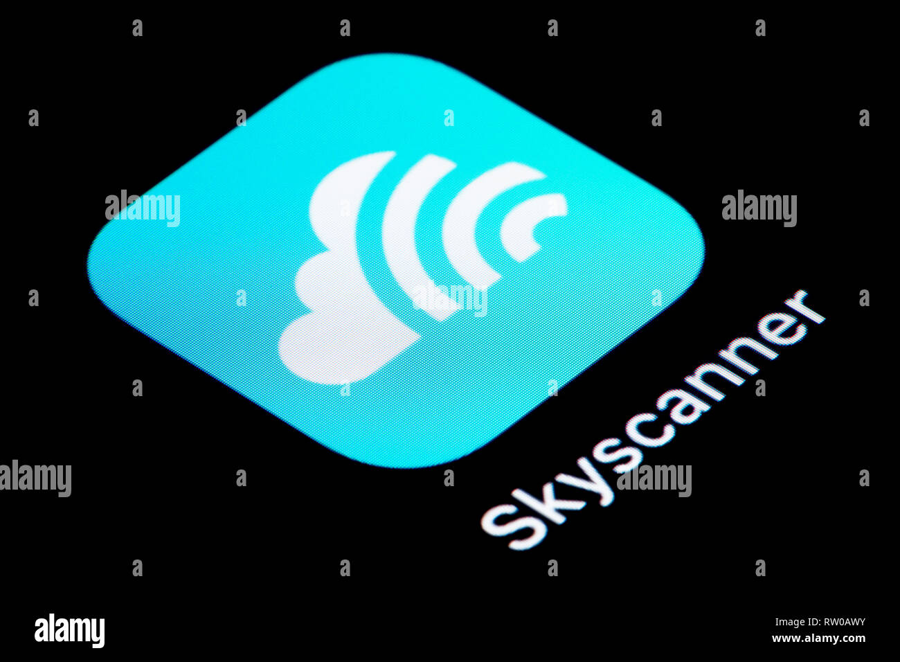 A close-up shot of the Skyscanner app icon, as seen on the screen of a ...