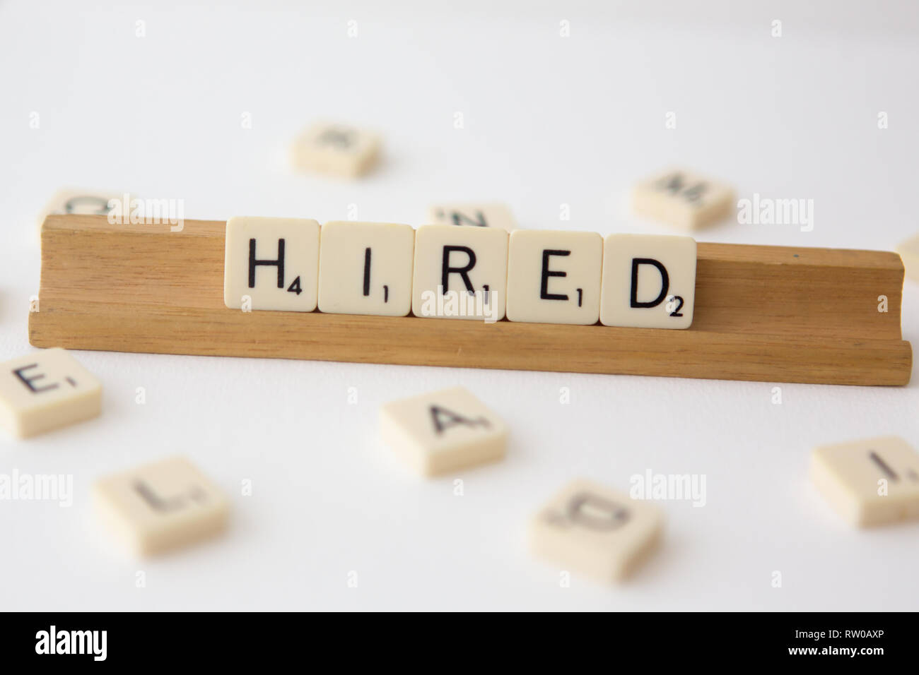 Tiles spell out the word 'hired' Stock Photo - Alamy