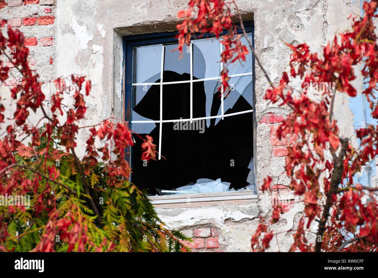 Old building with a collapsing brick facade and broken window glass and ...