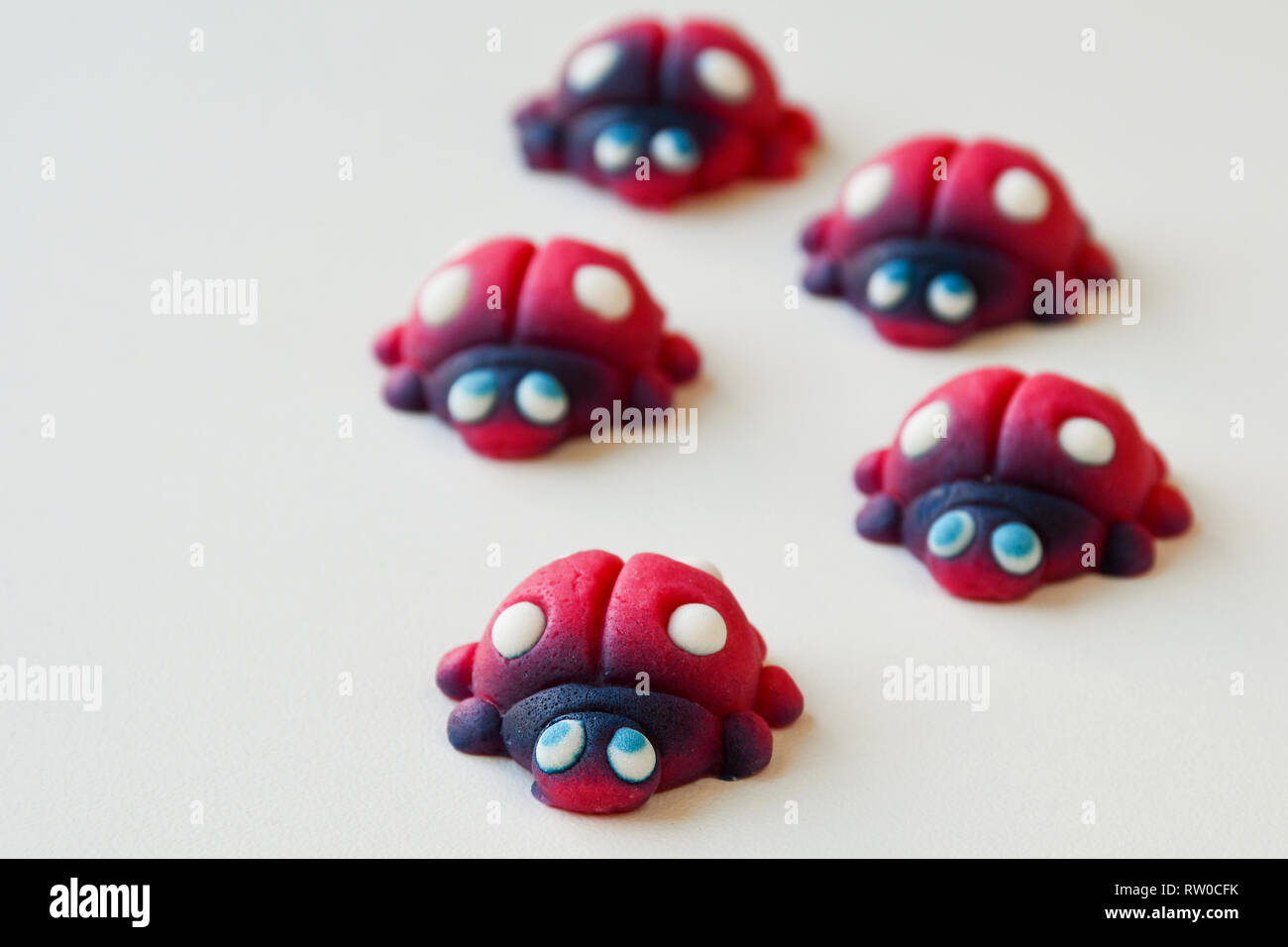 Group of red ladybugs with blue eyes and white dots made from sweet ...