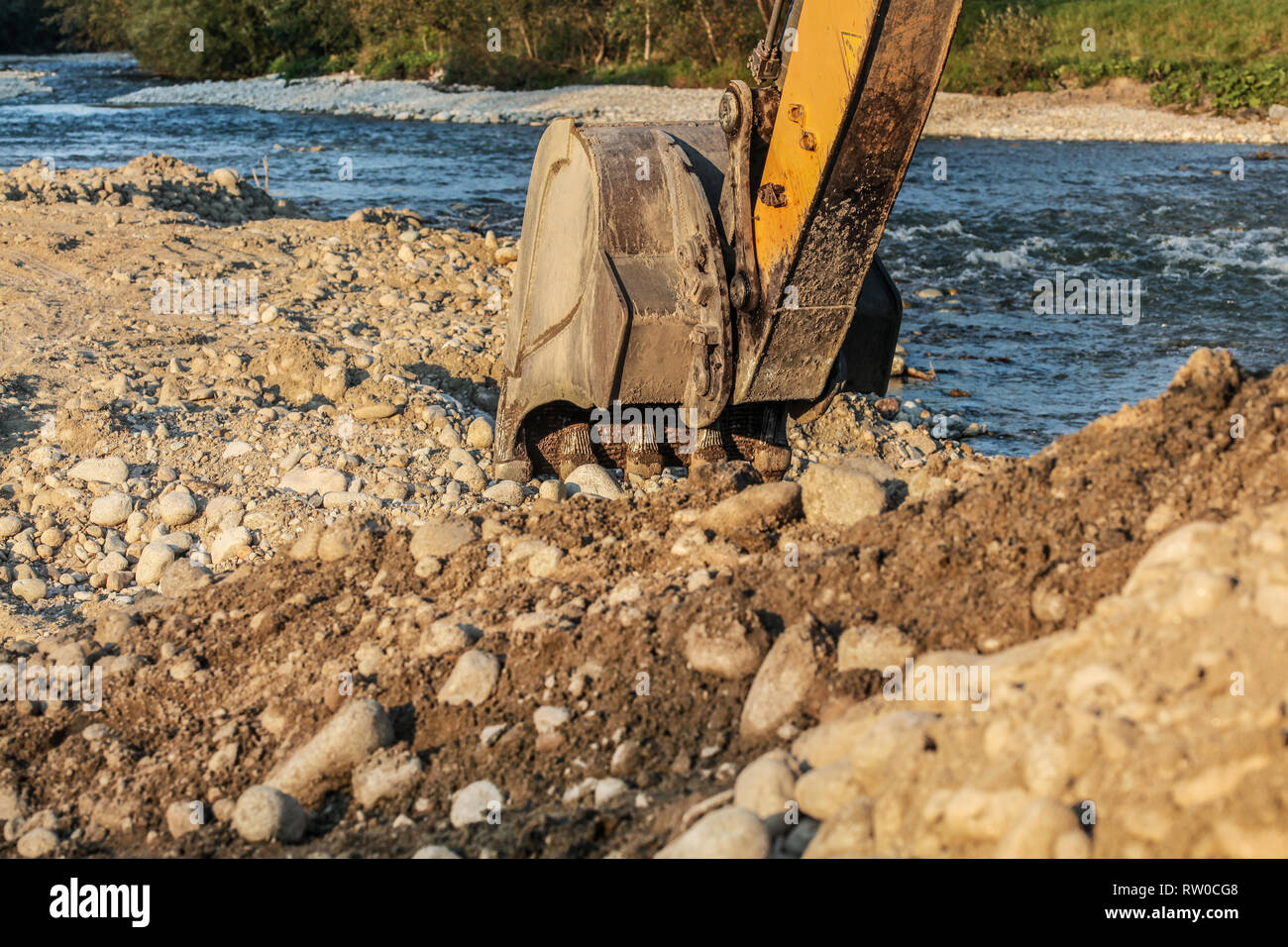 Excavator (digging machine) bucket digging ground by the river Stock ...