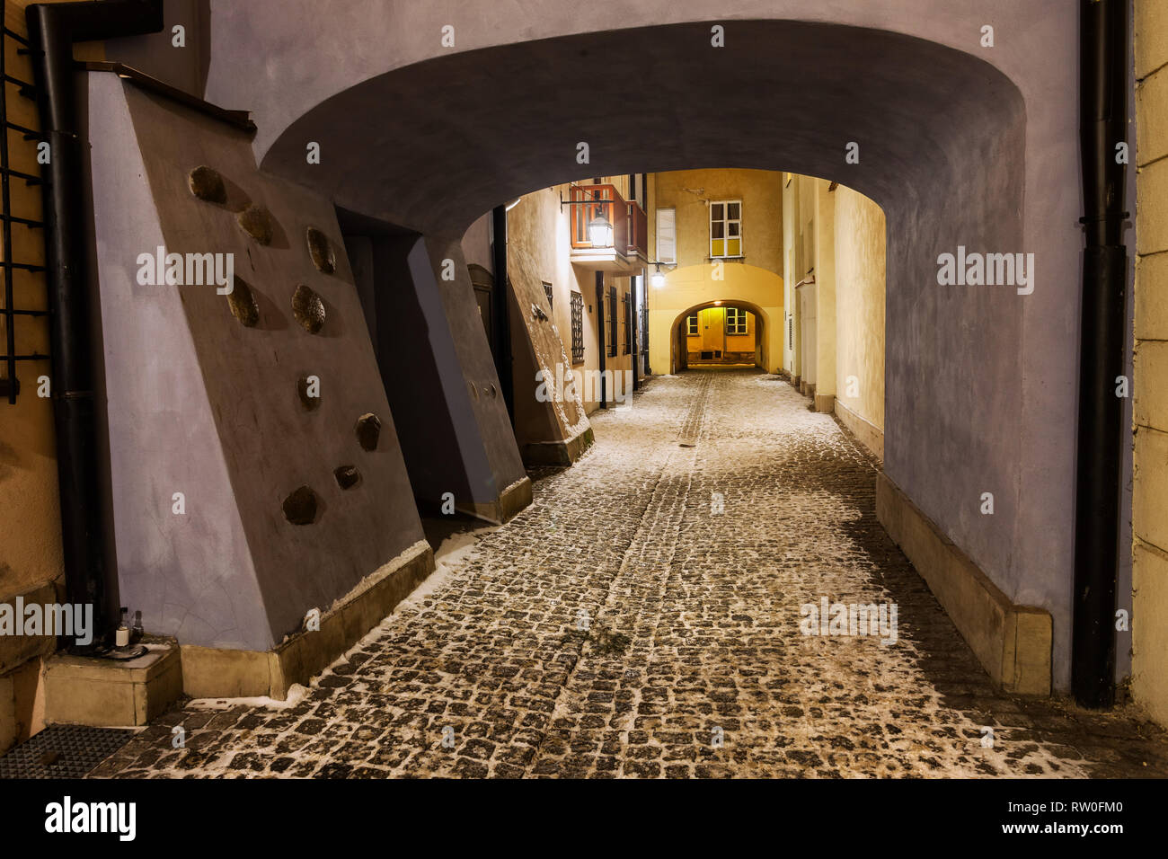 Narrow snowy cobblestone street on winter night in the Old Town of ...