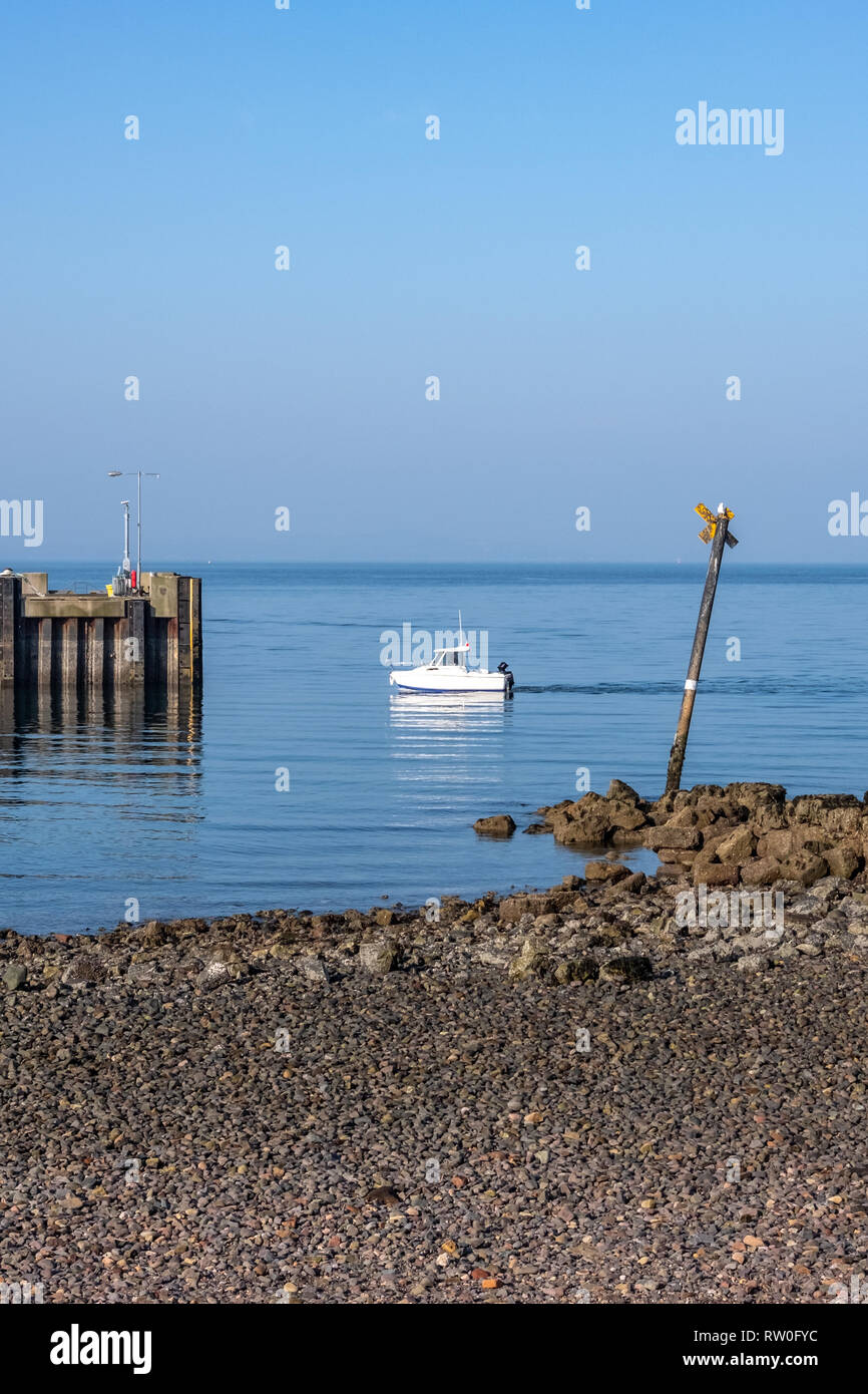 Unusually warm February weather for Largs Pier and a small white boat ...