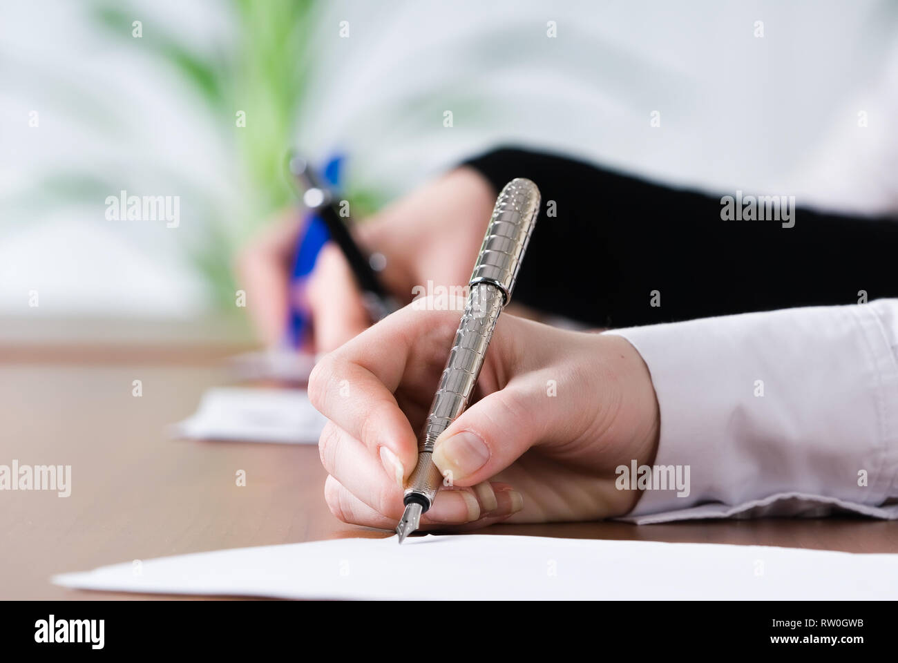 Female person's hand signing an important document Stock Photo - Alamy