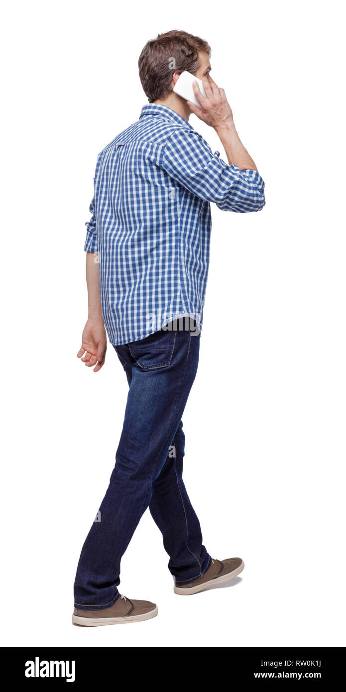 side view of man walking with a mobile phone. backside view of person ...