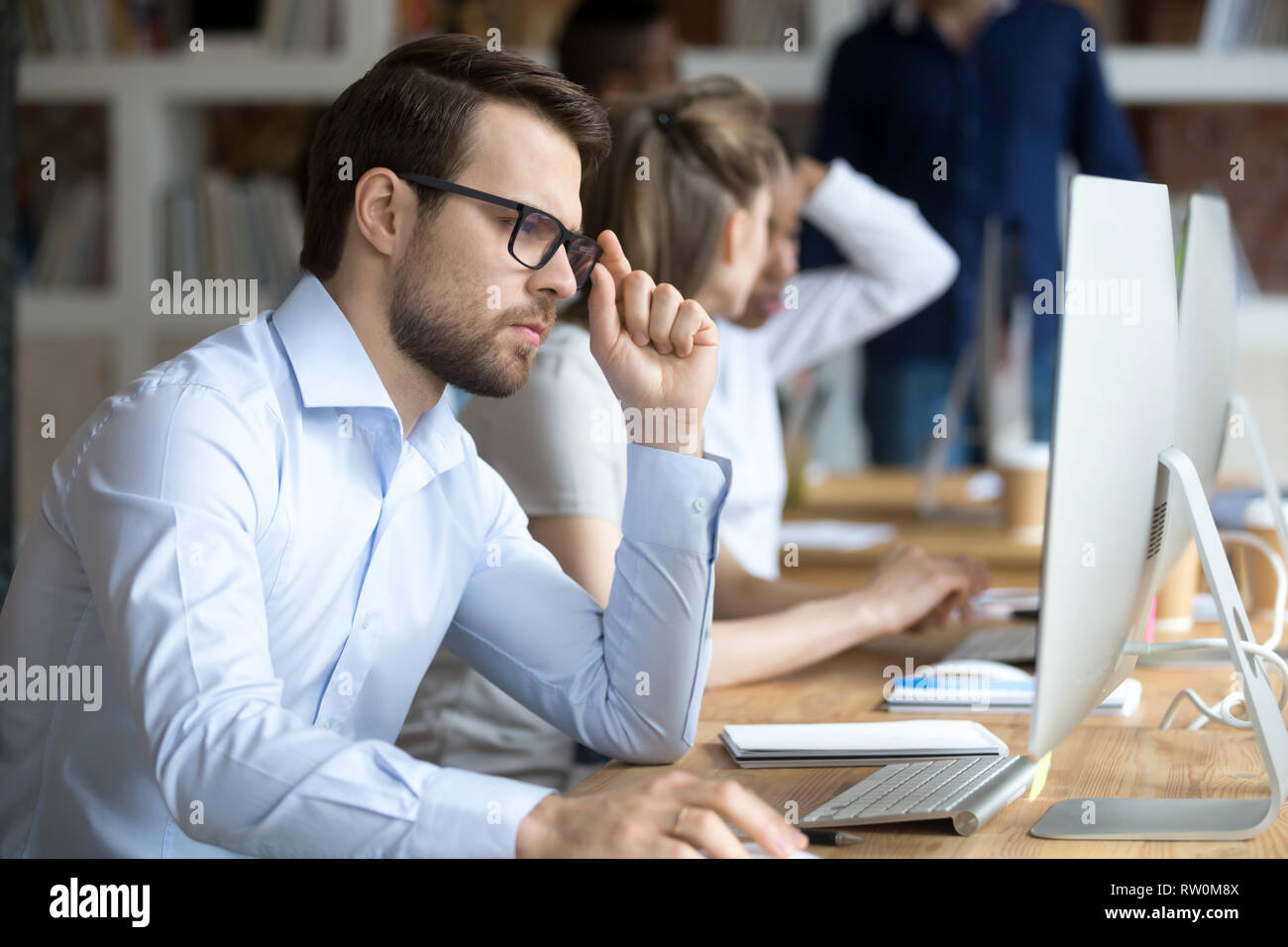 Confident pensive employee working in shared office Stock Photo - Alamy