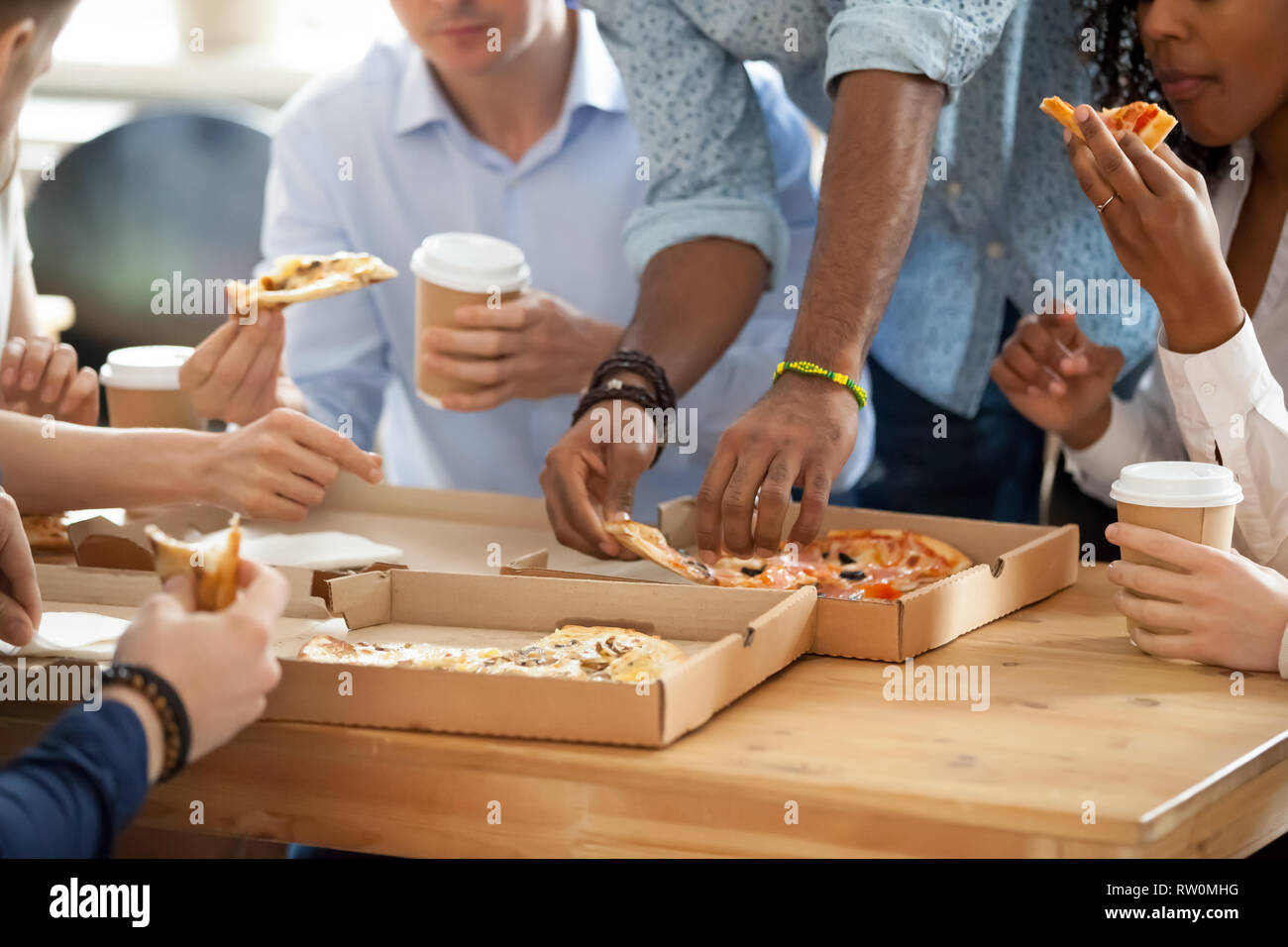 Diverse employees eating pizza during lunch break Stock Photo - Alamy