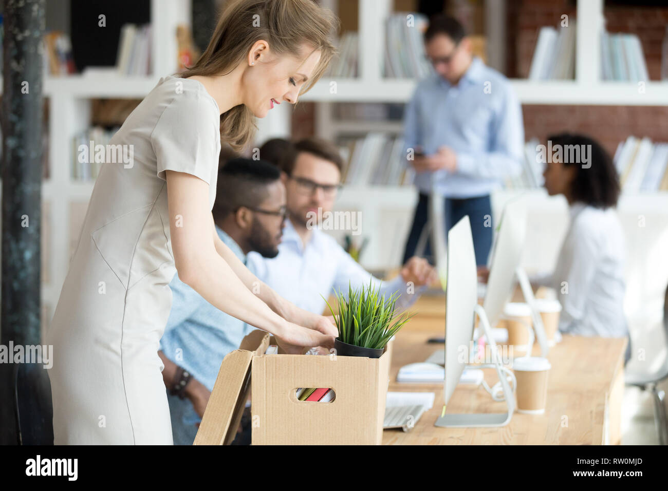 Woman unpack box with belongings on first working day Stock Photo - Alamy