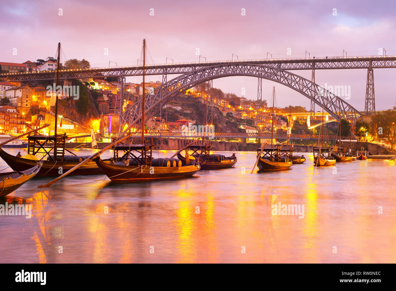 Scenic sunset over Douro river with traditional wine boats, illuminated ...