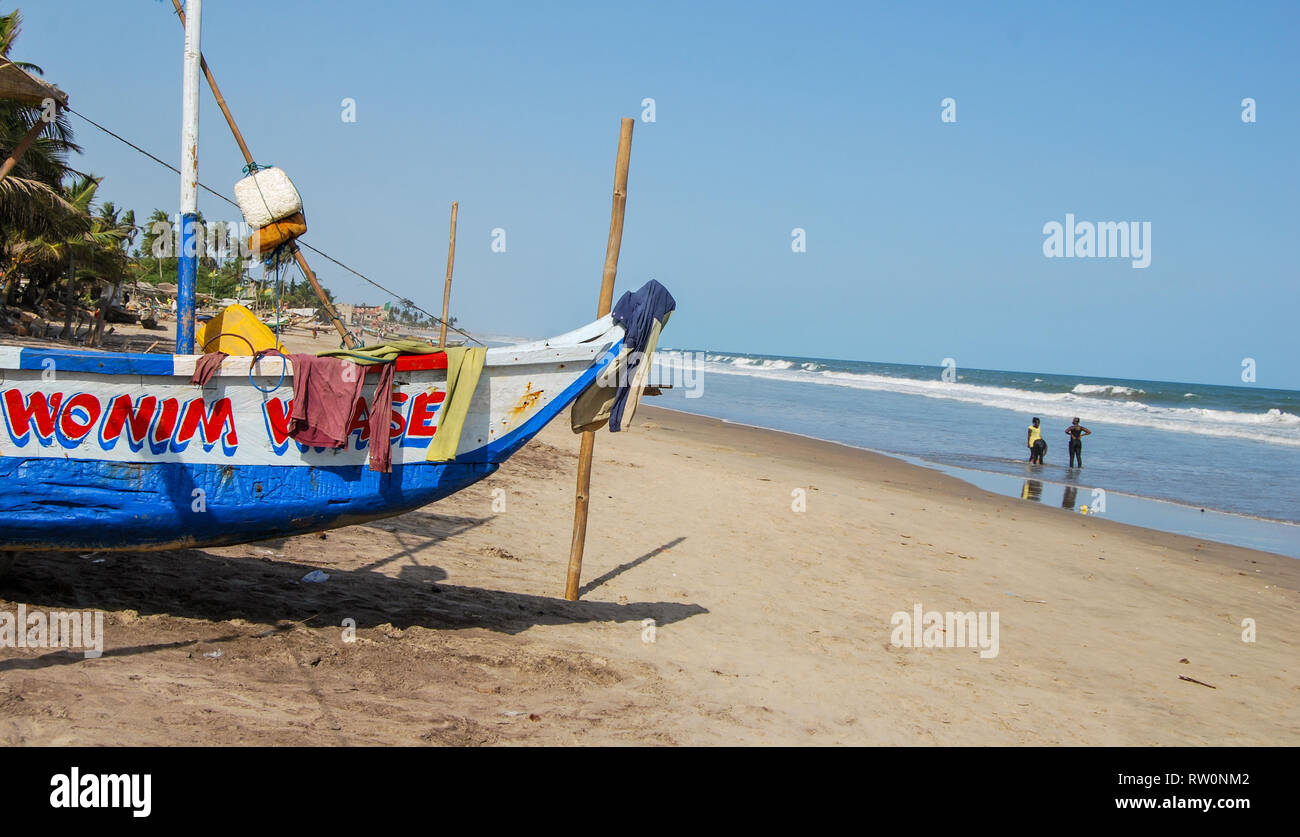 A colorful (blue and red) boat docked at a tropical sandy beach in ...