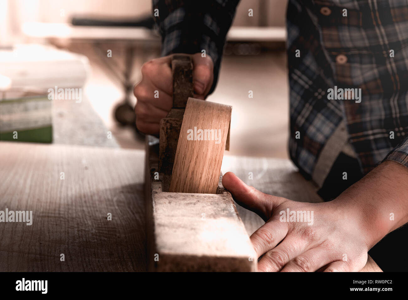 Carpenter working on wood using wood retro old ancient planer. Workshop ...