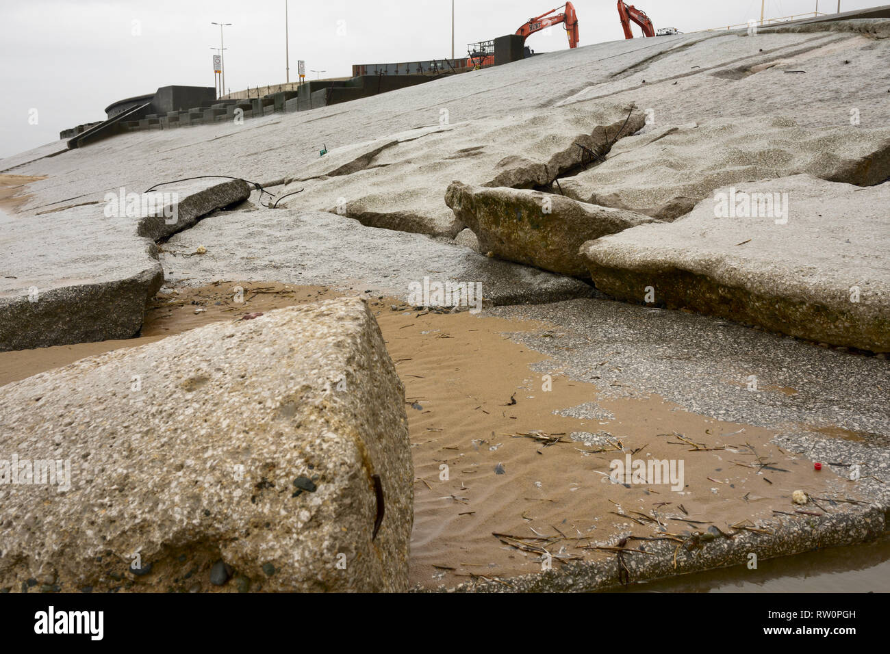 Damaged reinforced concrete sea wall, coastal flood defences with ...