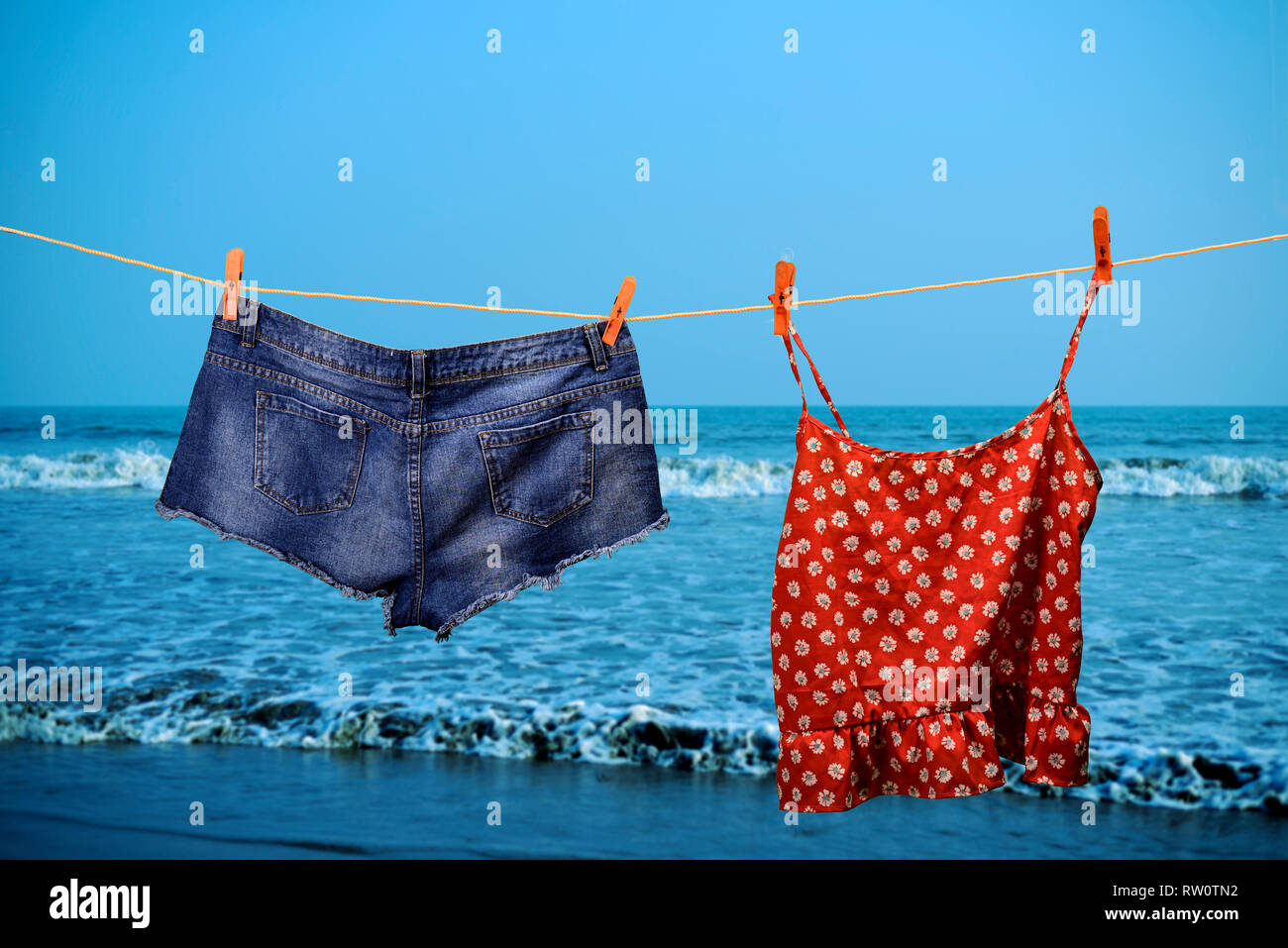 Women casual clothing are hanging in a rope in a sea beach Stock Photo ...