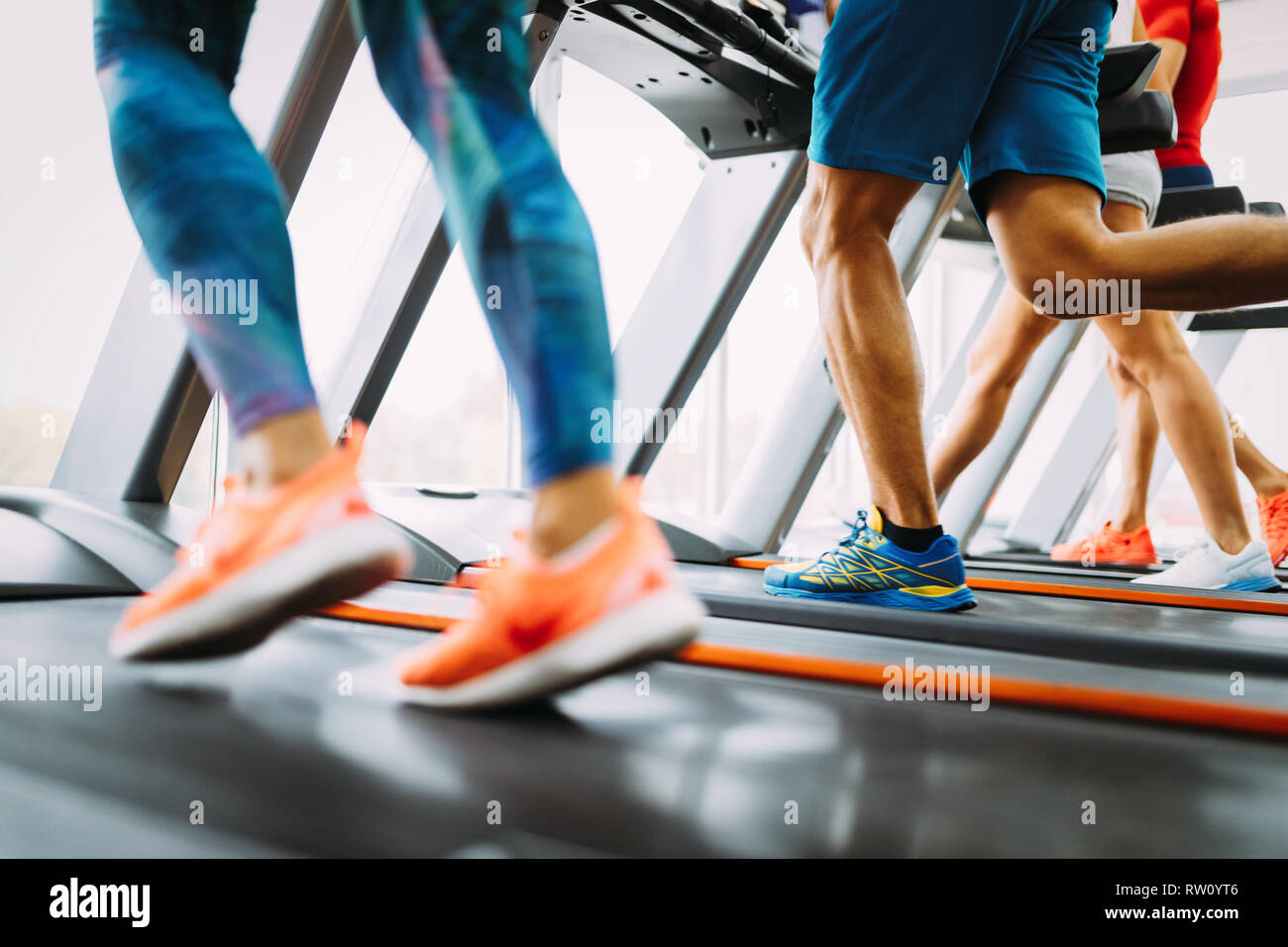 Healthy man and woman running on a treadmill in a gym Stock Photo - Alamy