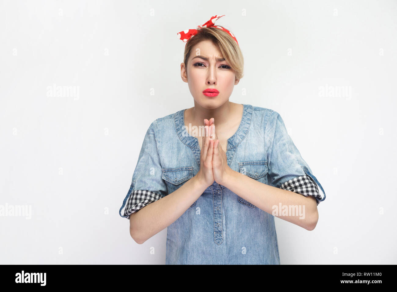 Please help me. Portrait of sad hopeful young woman in blue denim shirt ...