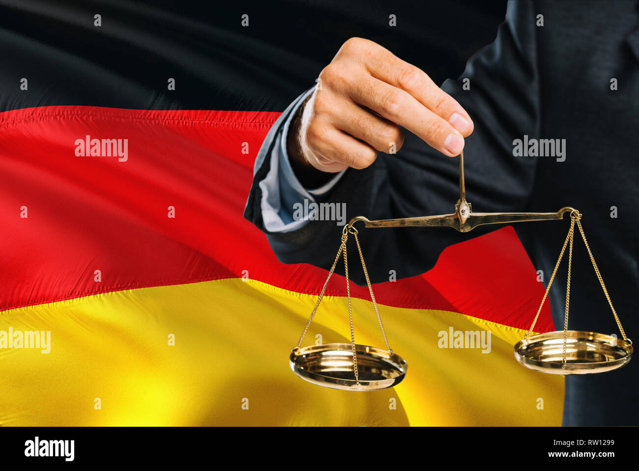 German Judge is holding golden scales of justice with Germany waving ...