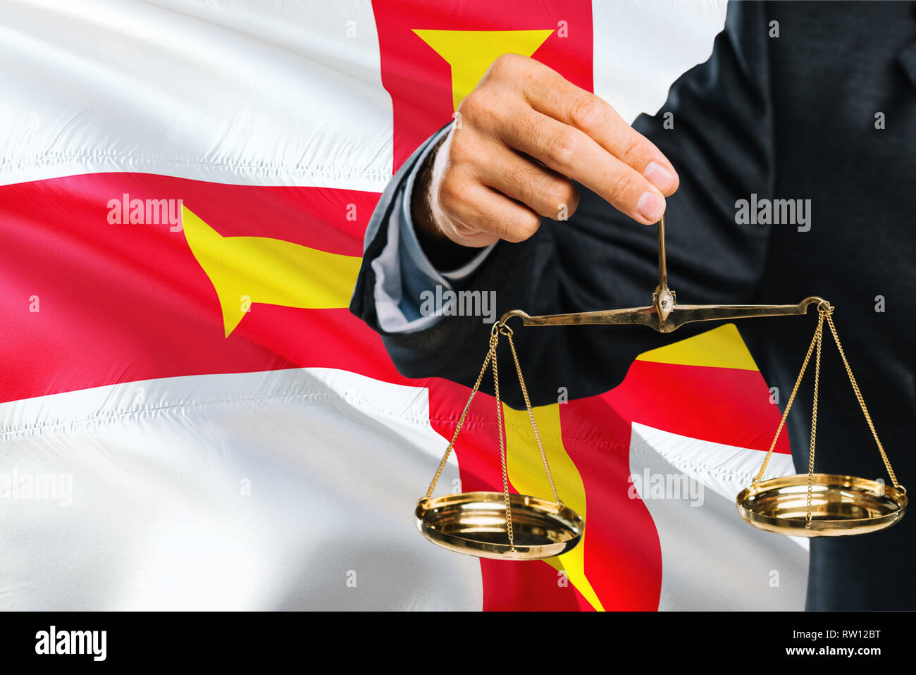 Judge Is Holding Golden Scales Of Justice With Guernsey Waving Flag