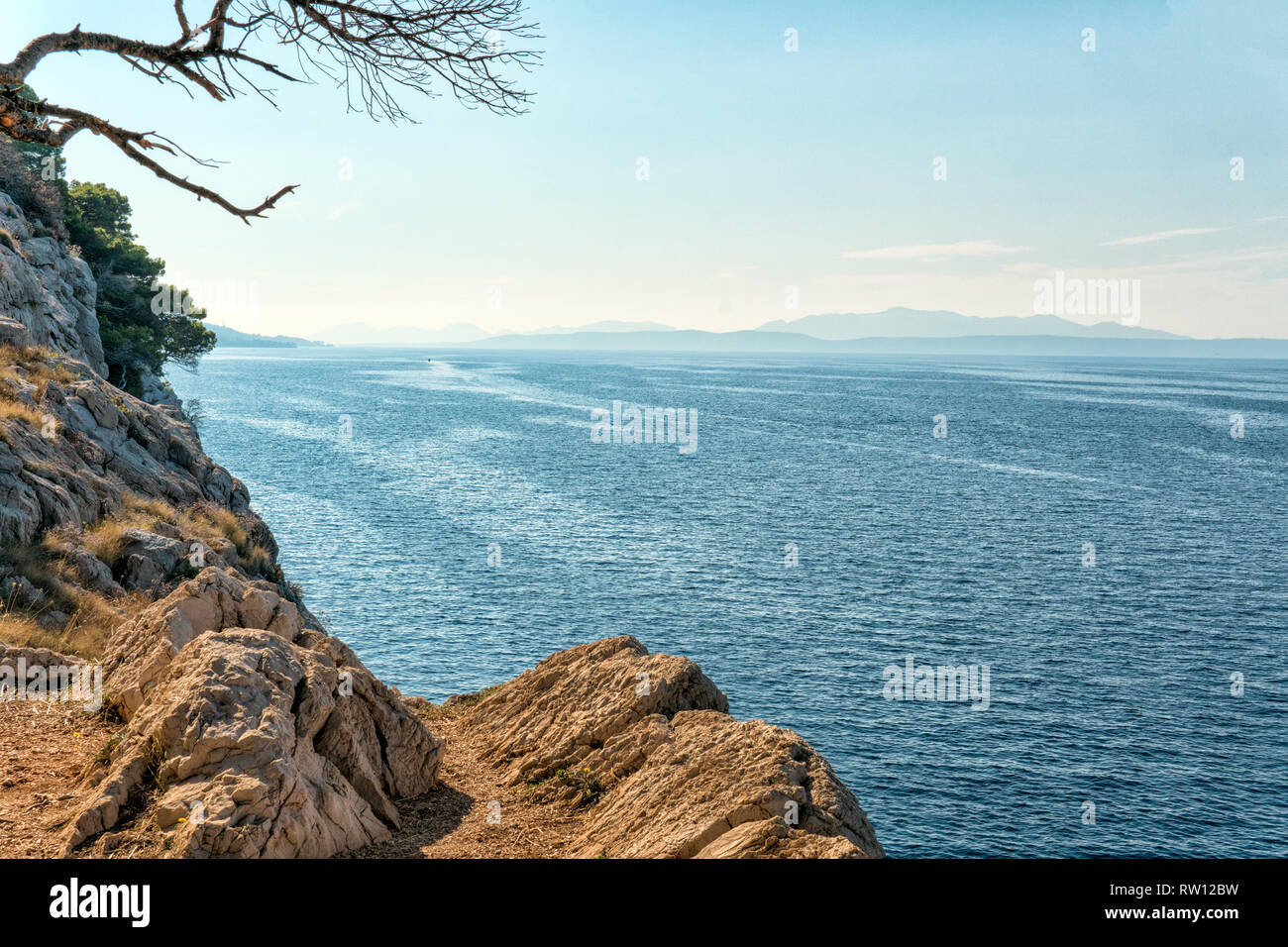 rocky coast and blue smooth sea Stock Photo - Alamy
