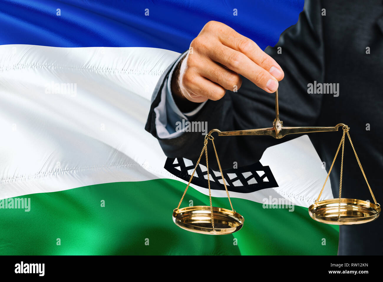 Judge is holding golden scales of justice with Lesotho waving flag ...