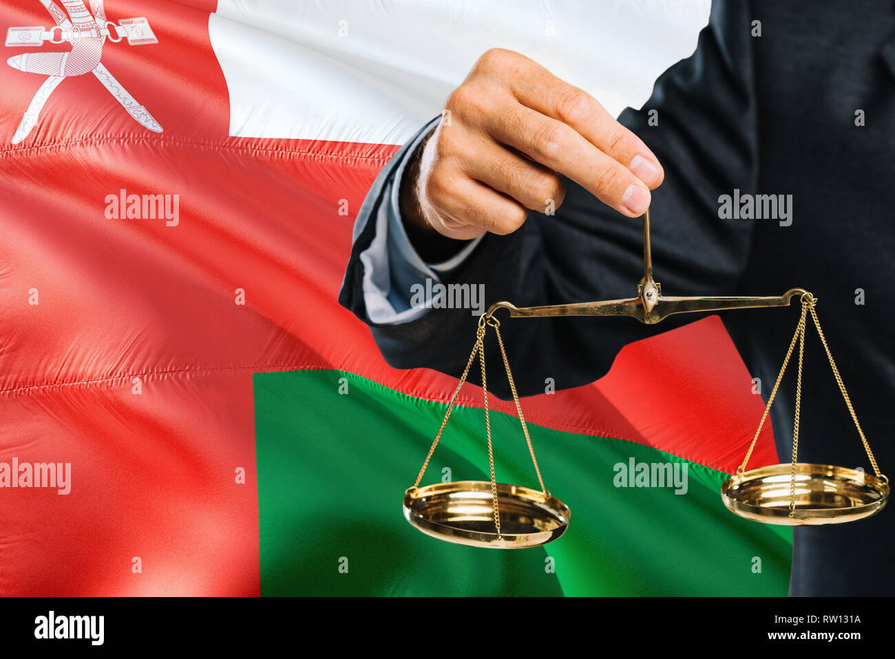 Omani Judge is holding golden scales of justice with Oman waving flag ...