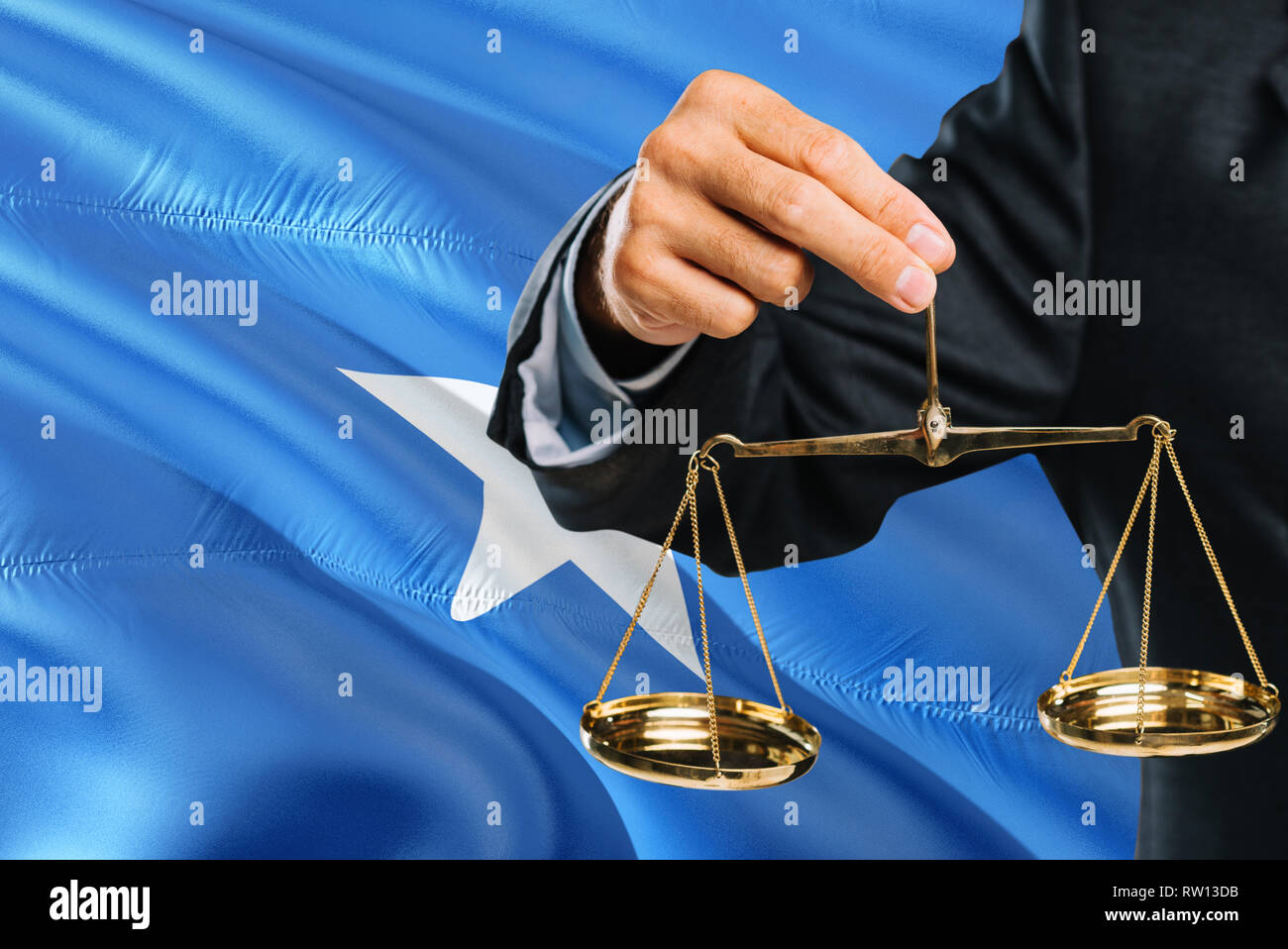 Somalian Judge is holding golden scales of justice with Somalia waving ...